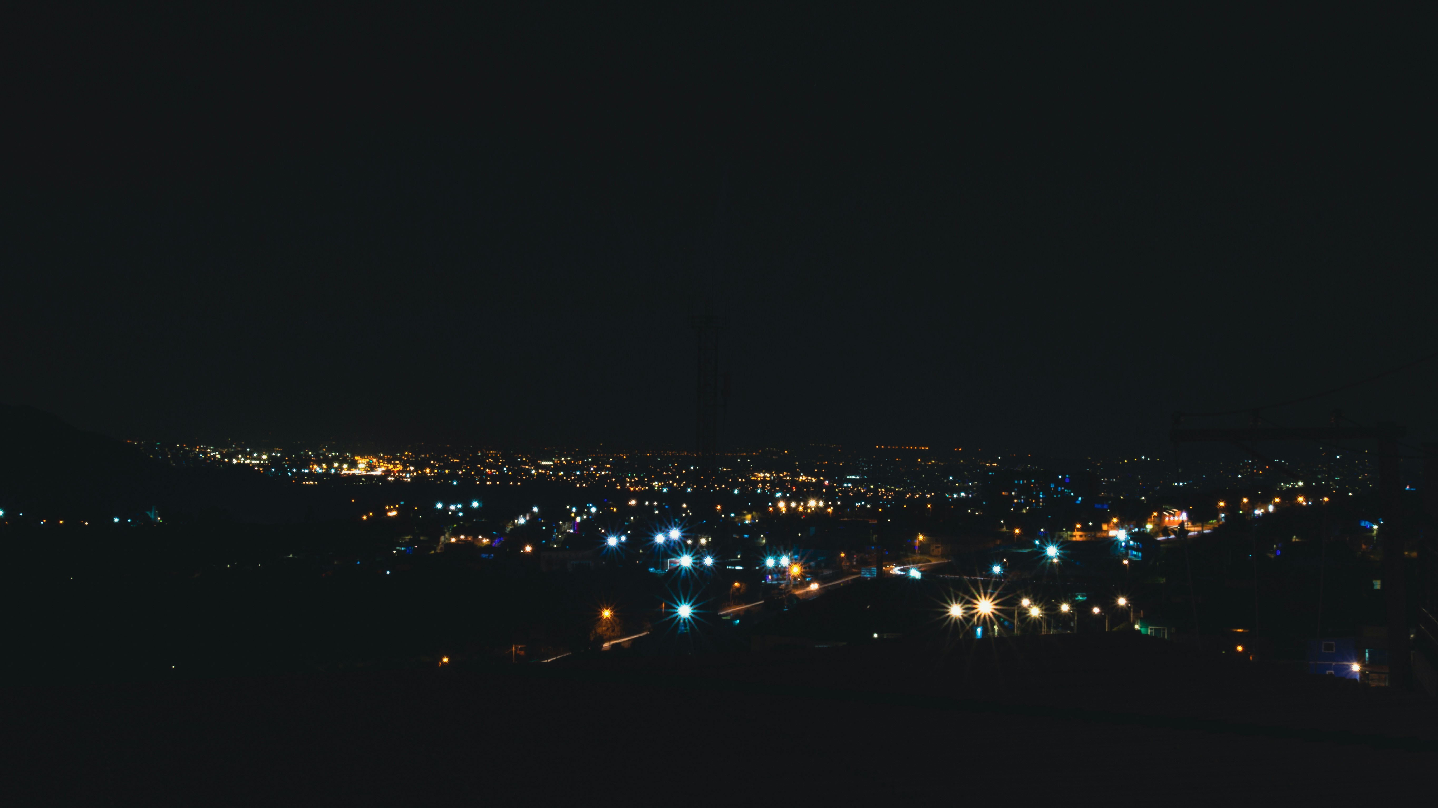 Vibrant city lights twinkle against a dark sky, showcasing the dynamic energy of urban life at night.