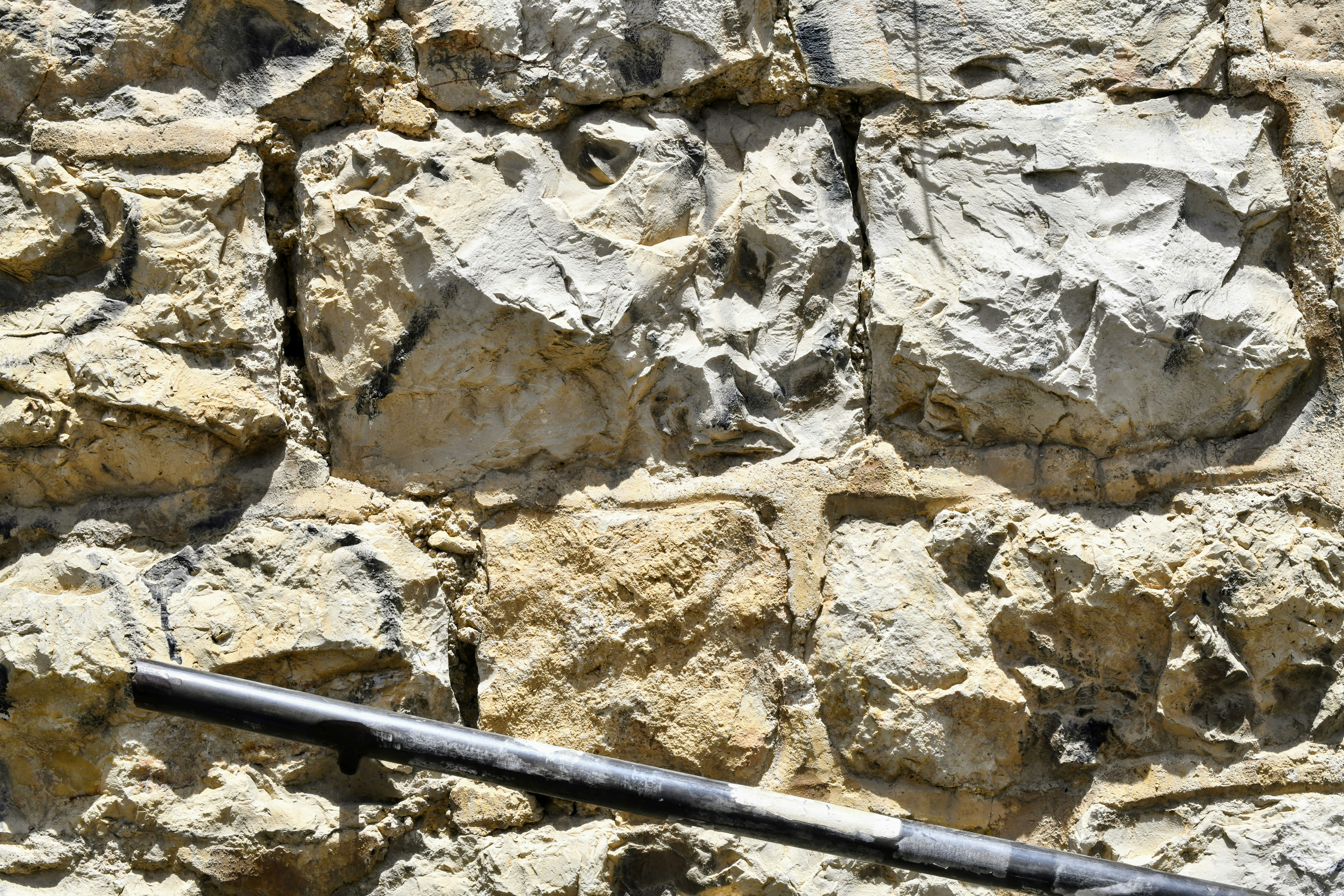 Iron Rod Across a Weathered Limestone Wall