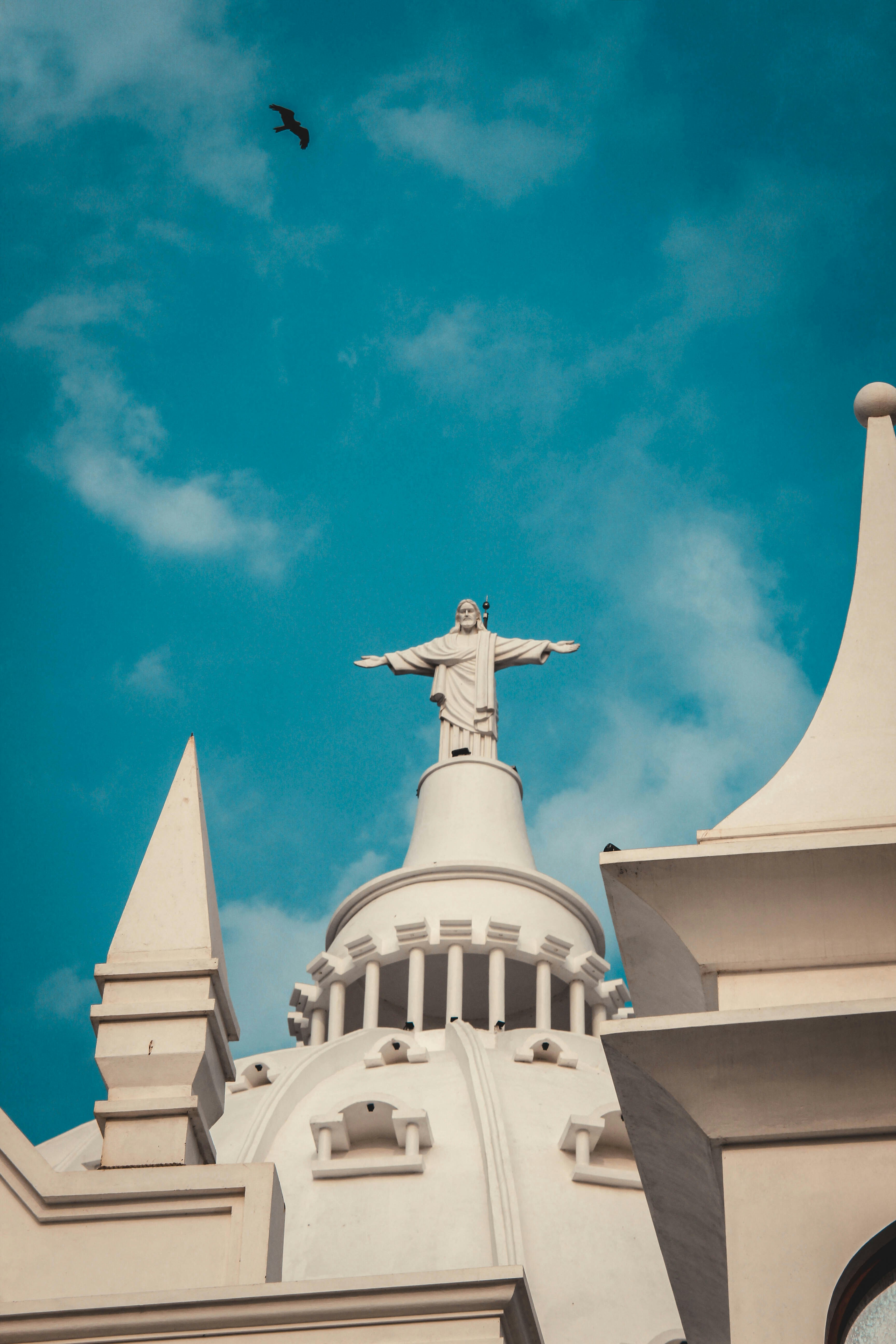 Angel of Architecture: A statue atop white domes against a cerulean sky