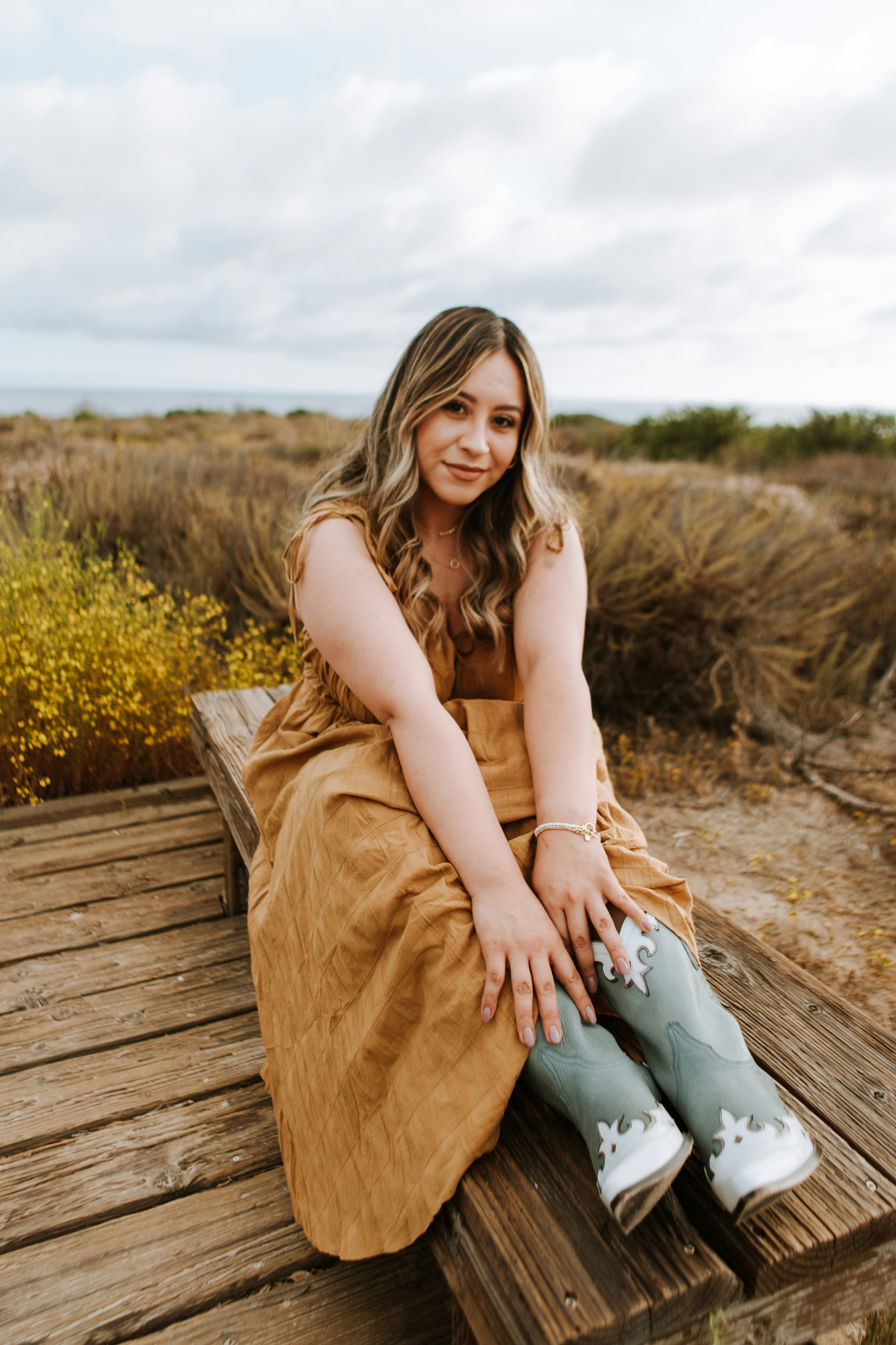 a woman sitting on top of a wooden bench