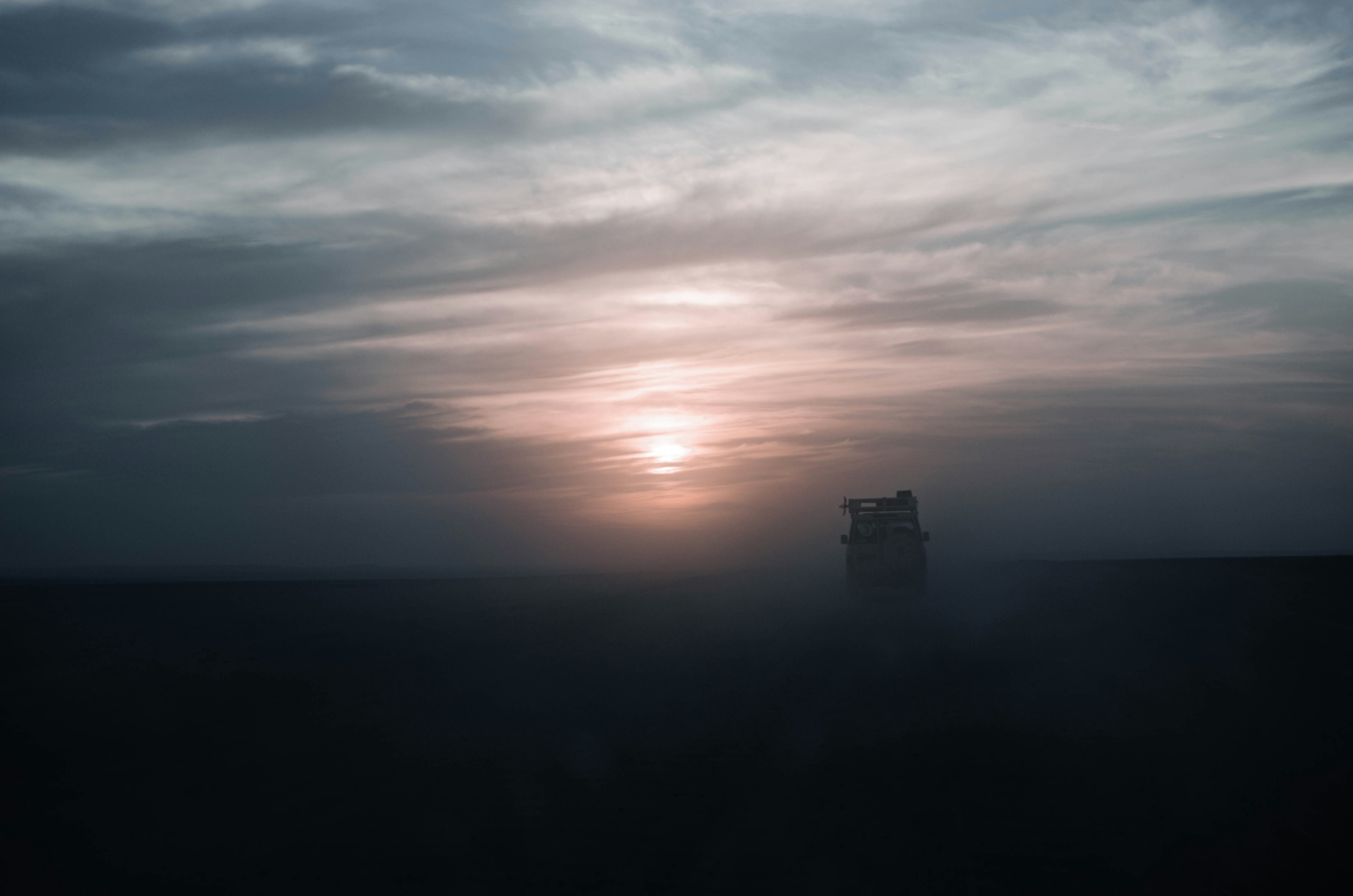 Dusk on a Flat Sea: A Lone Silhouette at the Horizon