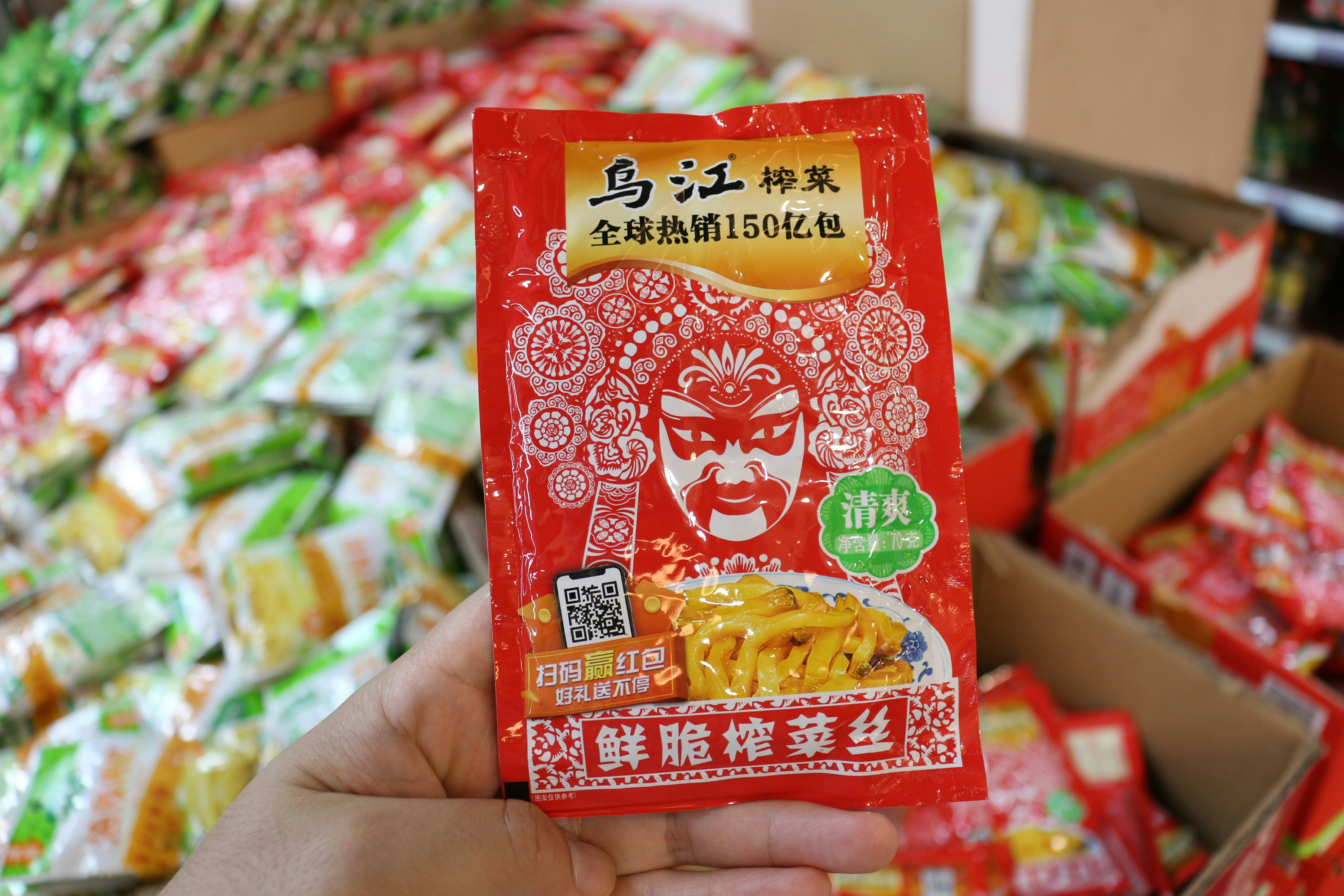 a person holding up a package of noodles
