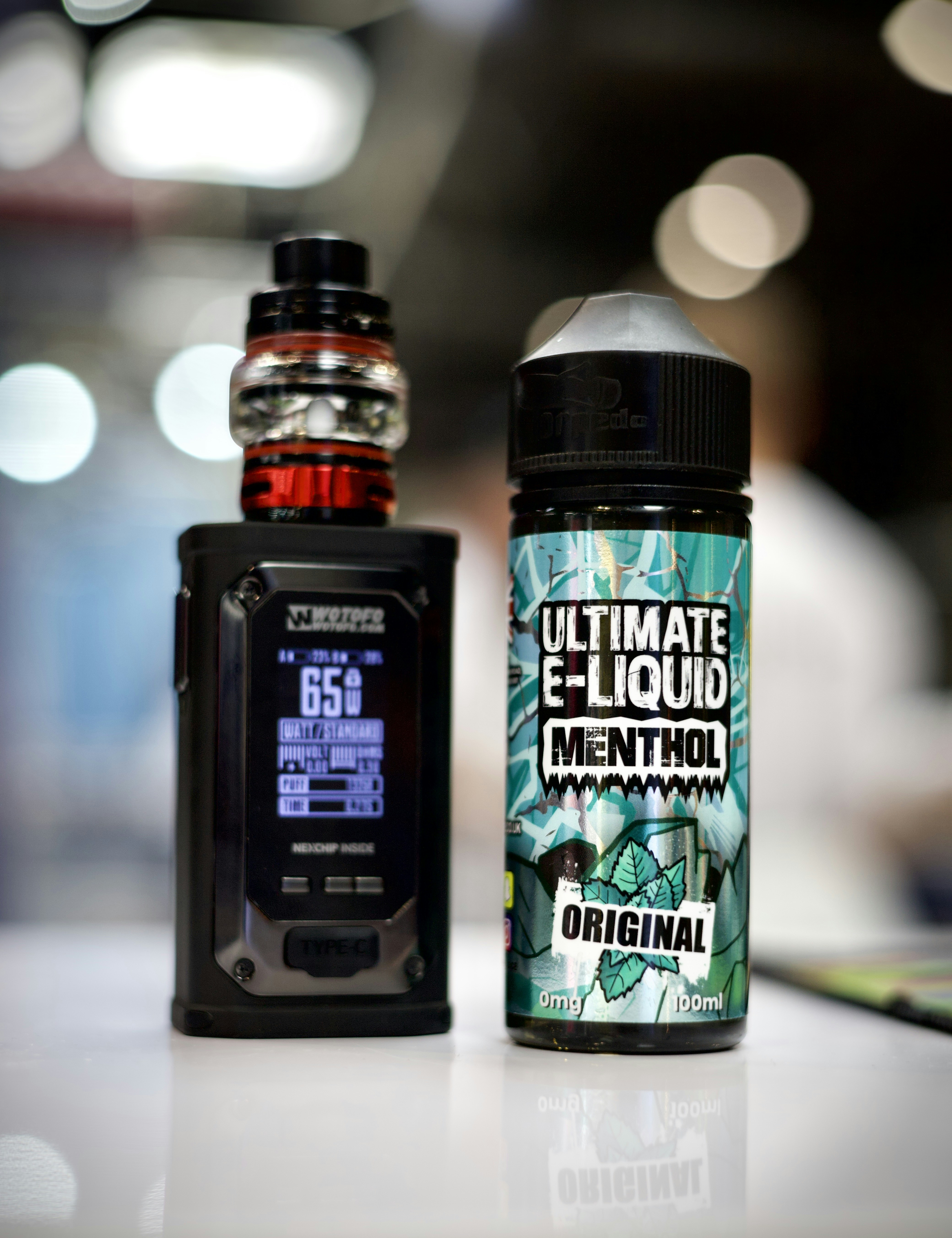 A bottle of e - liquid next to an electronic device photo – Free ...