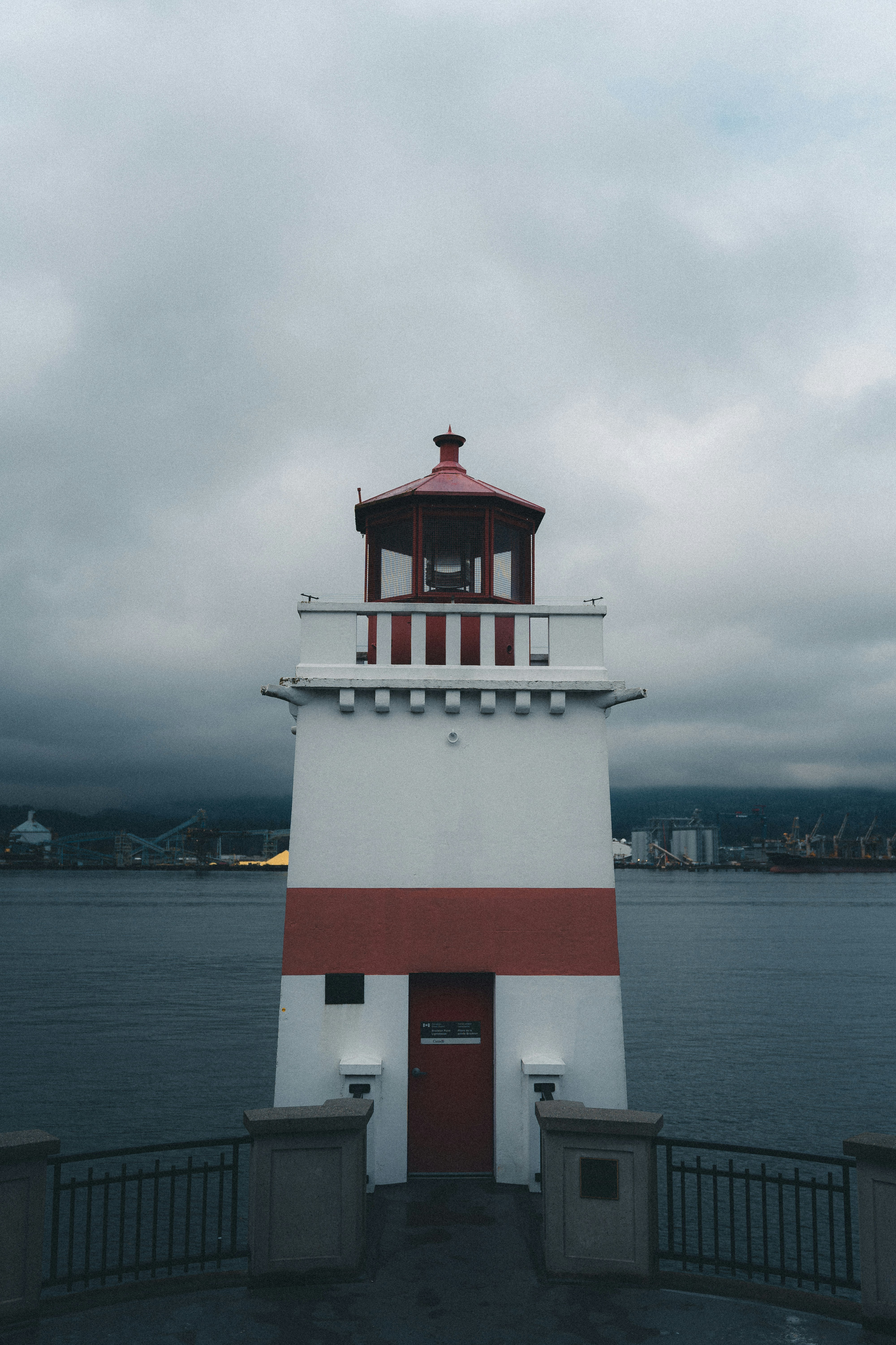 a red and white lighthouse sitting on top of a pier