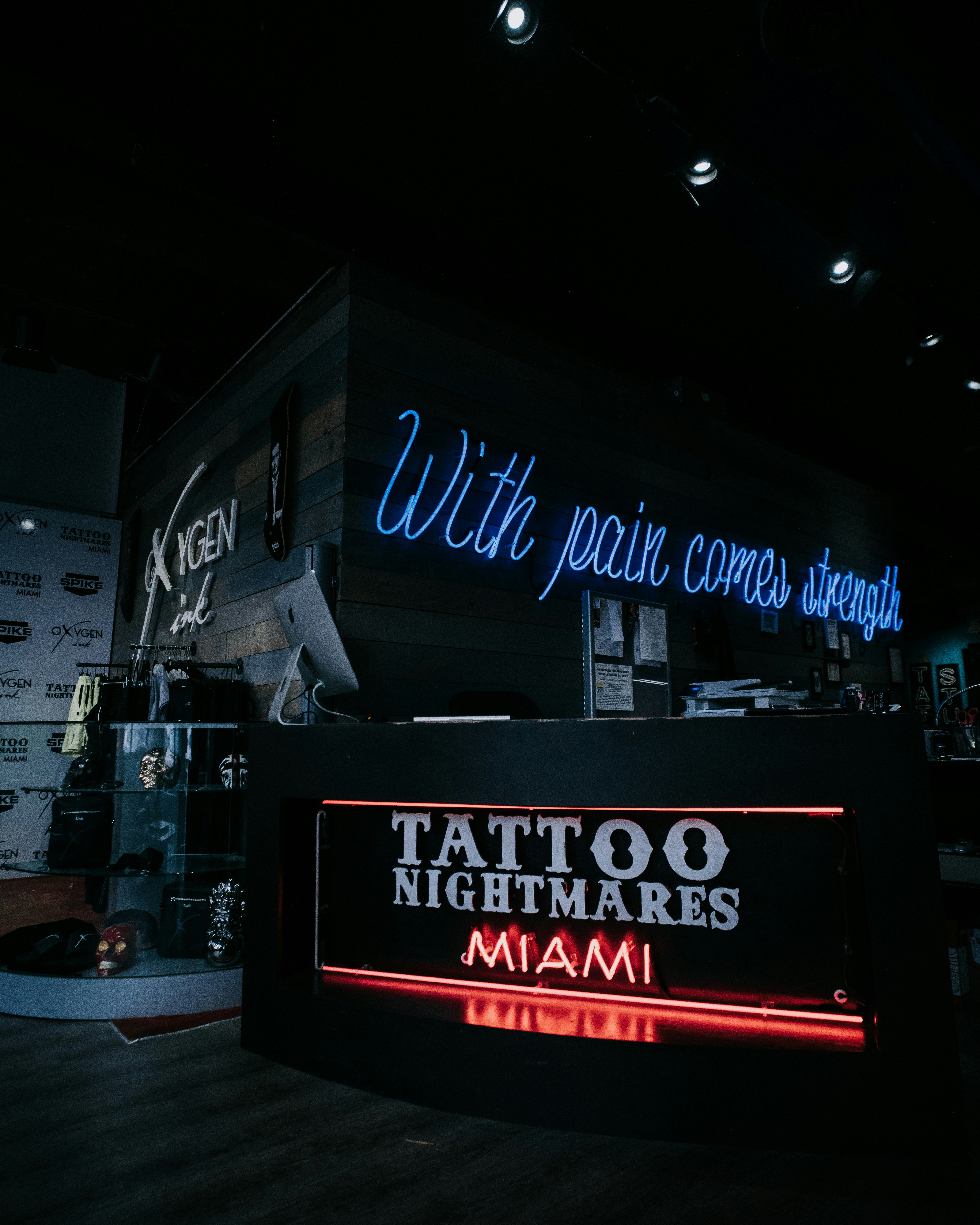 a tattoo shop with neon signs on the wall
