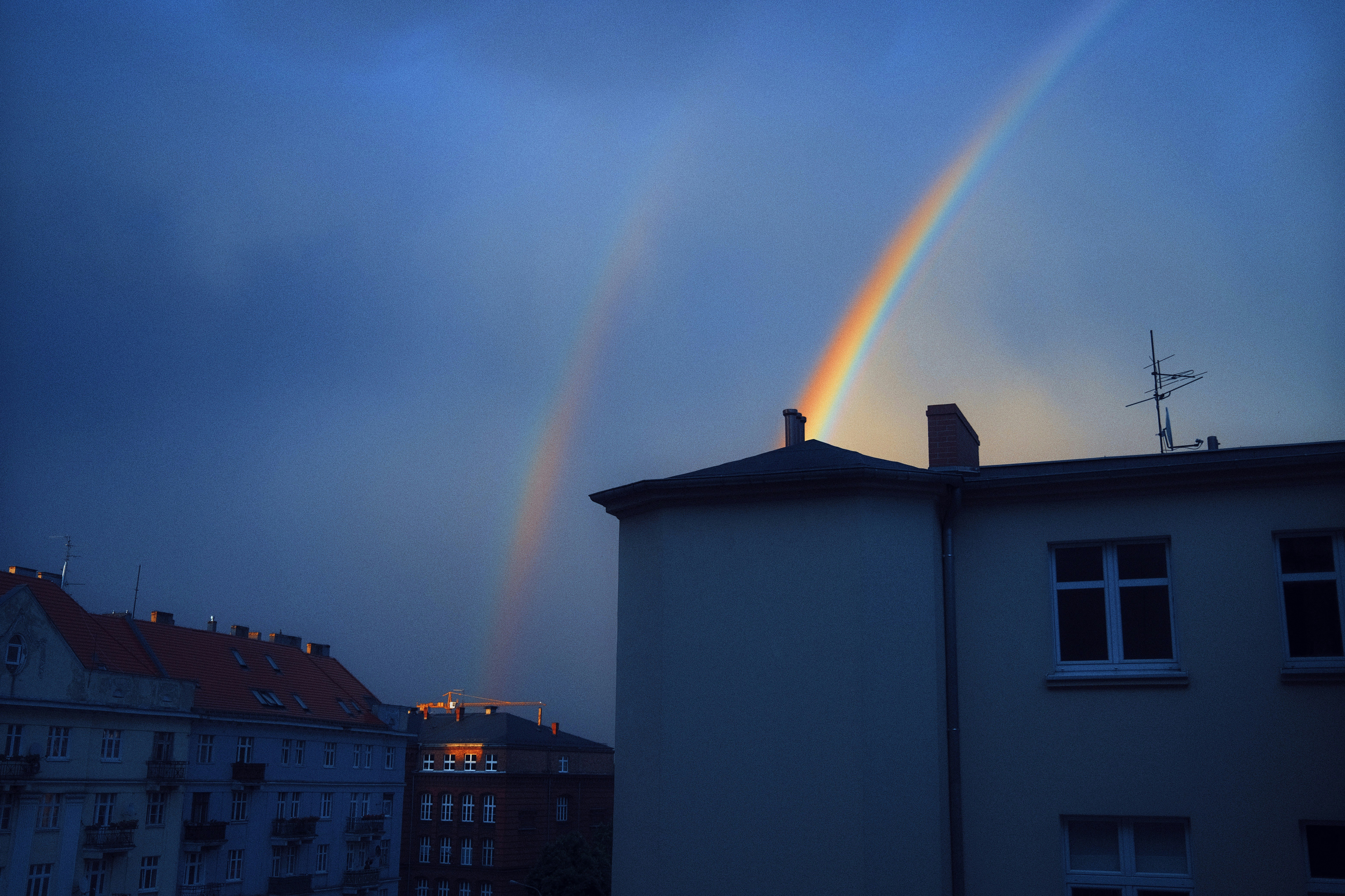 Twin Rainbows Over the City Rooftops at Dusk