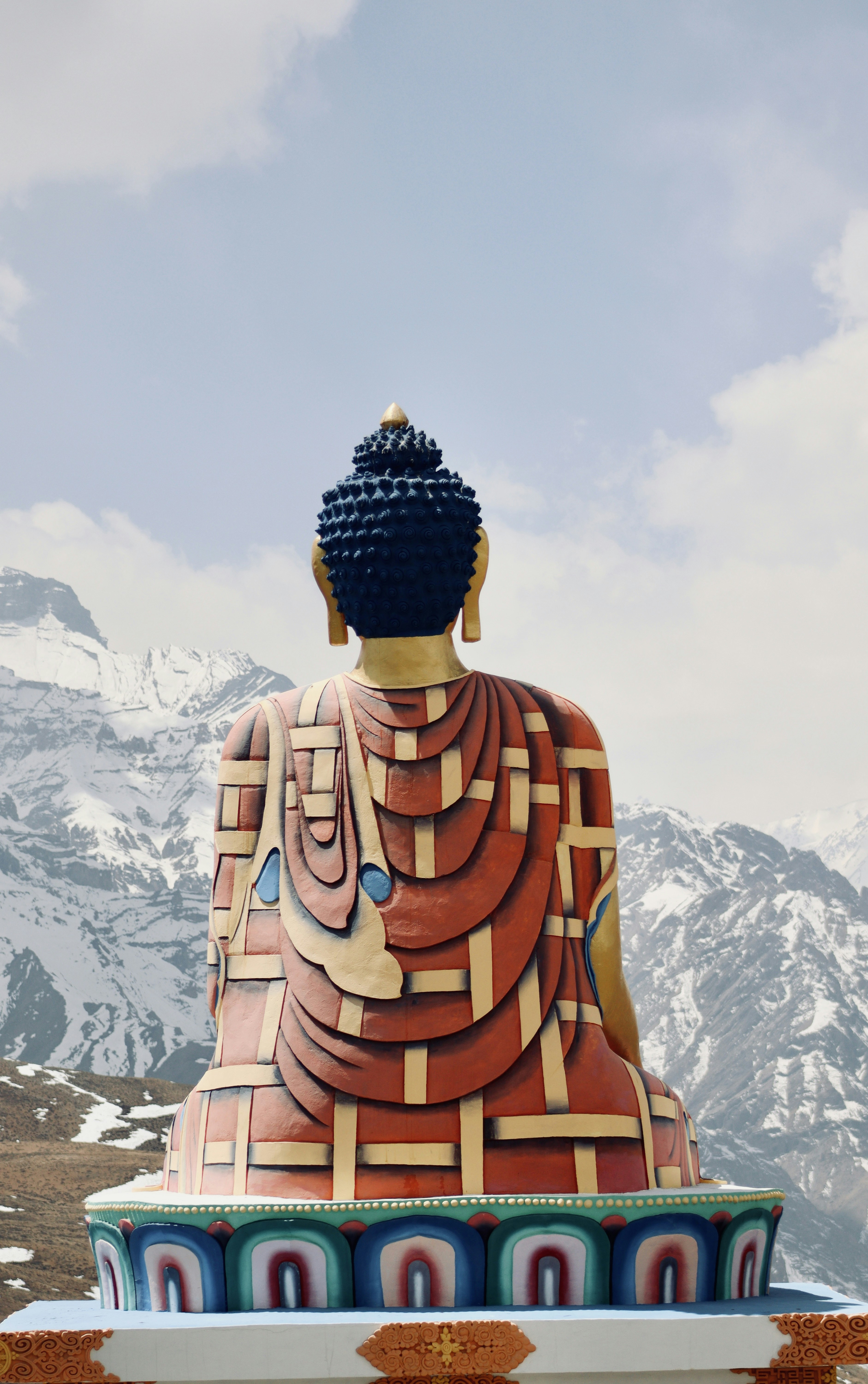 a large buddha statue sitting in front of a mountain