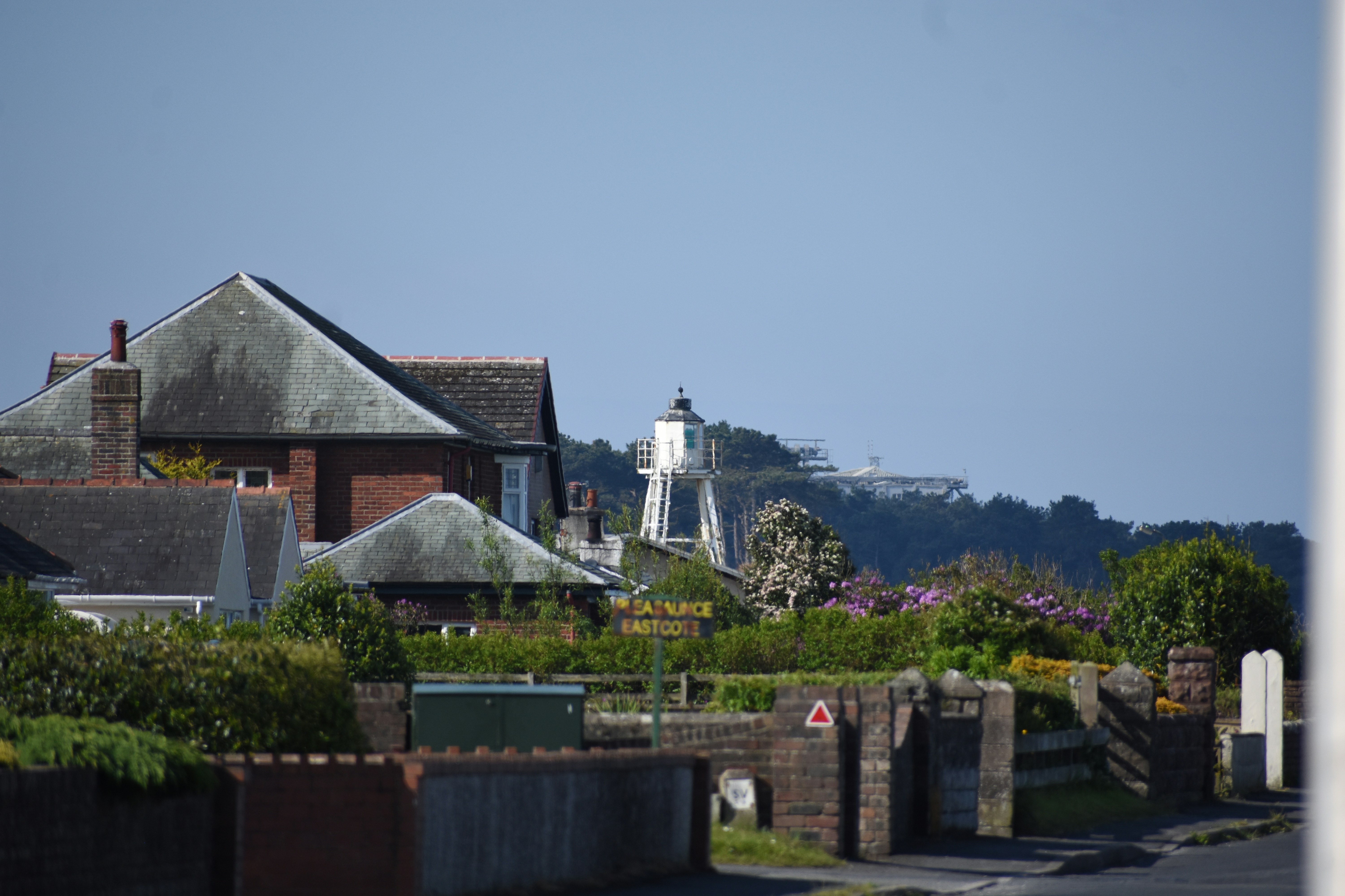 A street with houses and a lighthouse in the distance photo – Free ...
