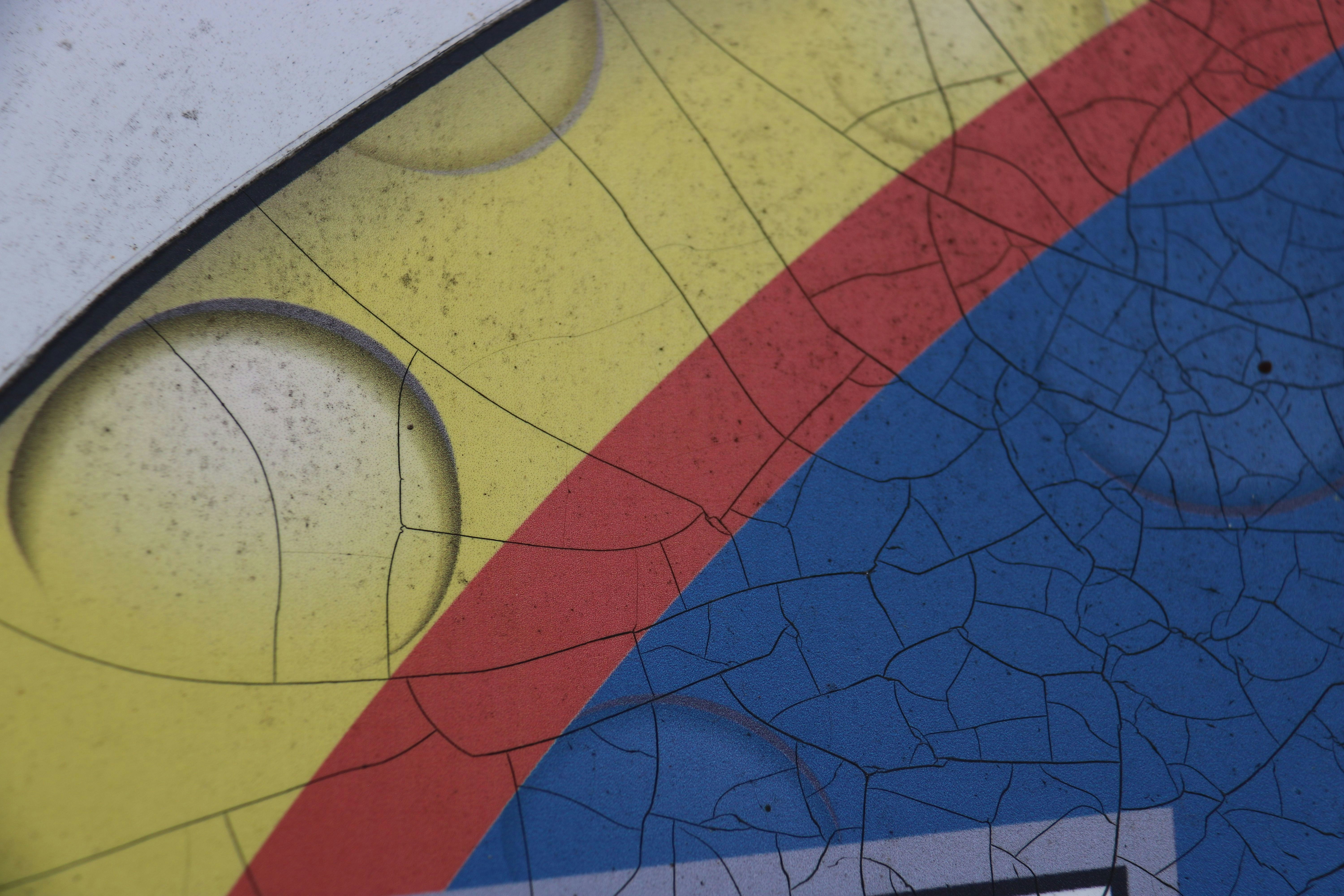 Cracked Color Arc: Water Droplets on a Curved Tricolor Surface