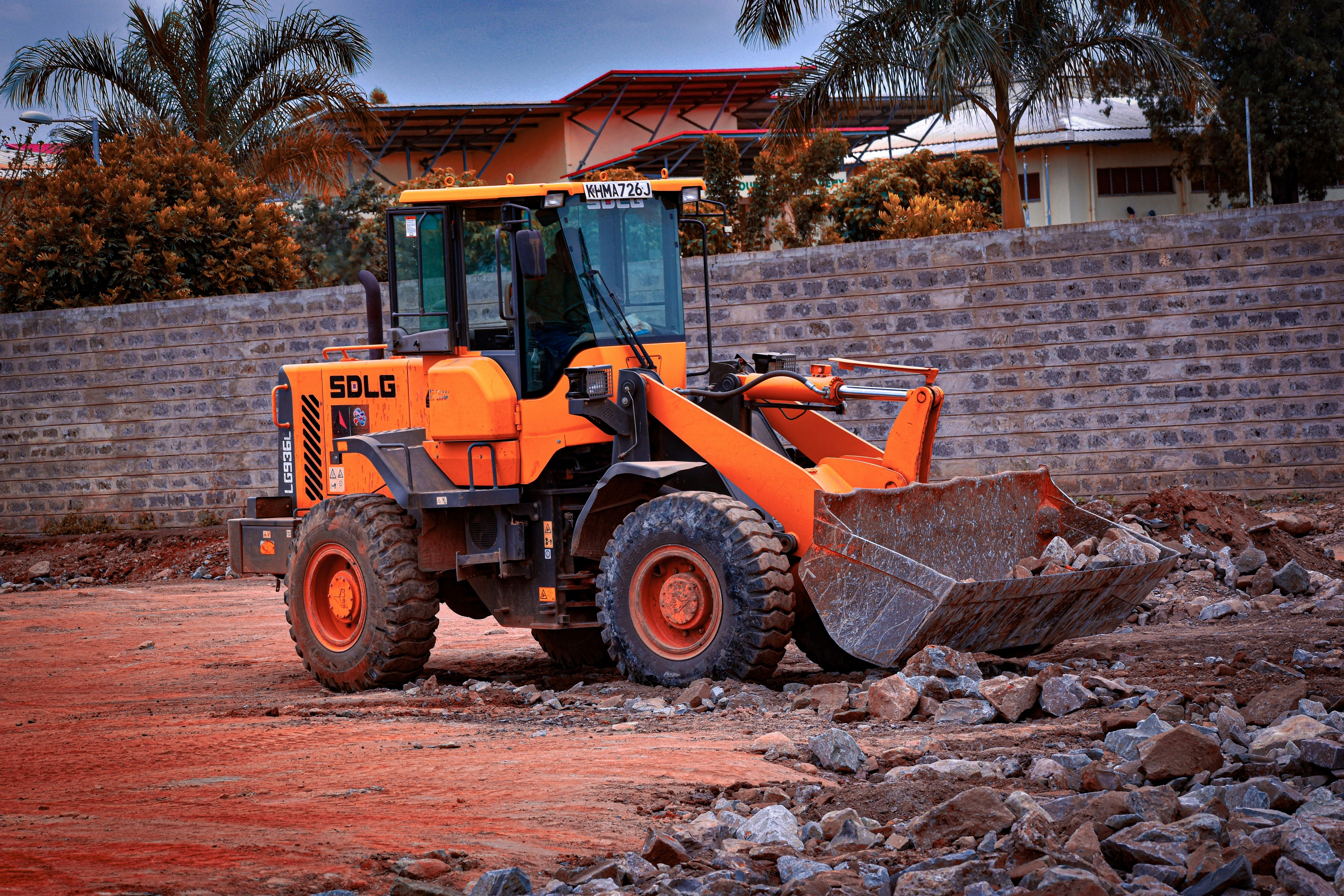 A large orange bulldozer sitting on top of a dirt field photo – Free ...