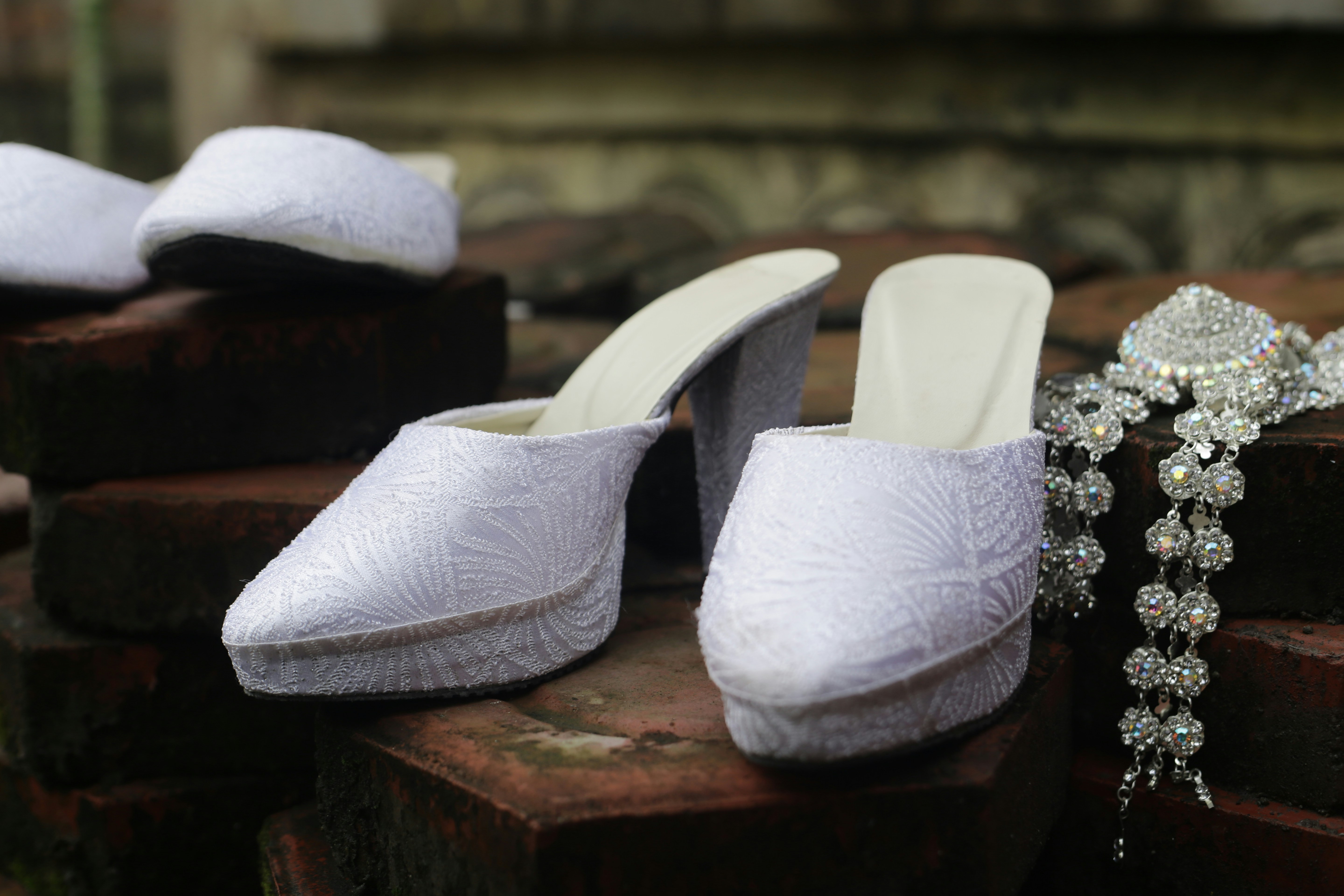 a pair of white shoes sitting on top of a brick wall
