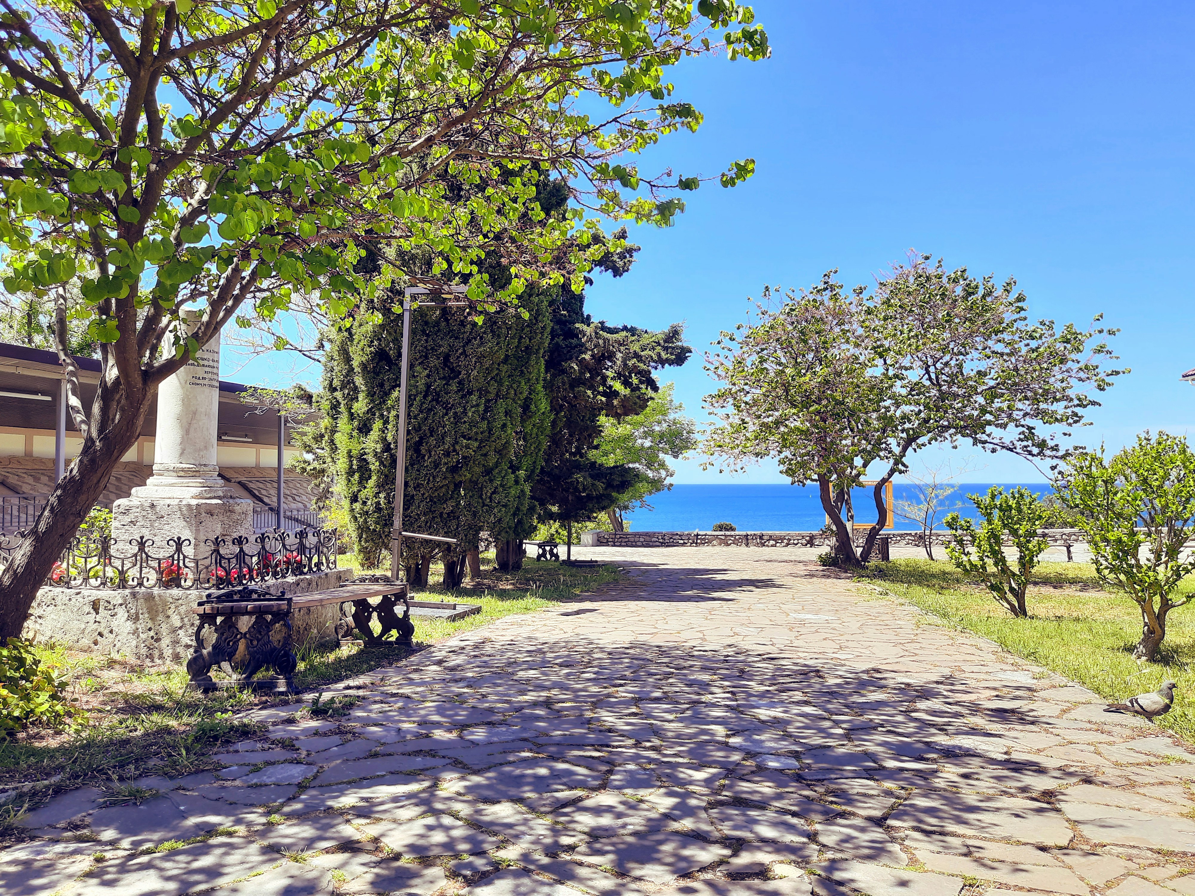 A stone road with a bench on the side of it photo – Free Path Image on ...