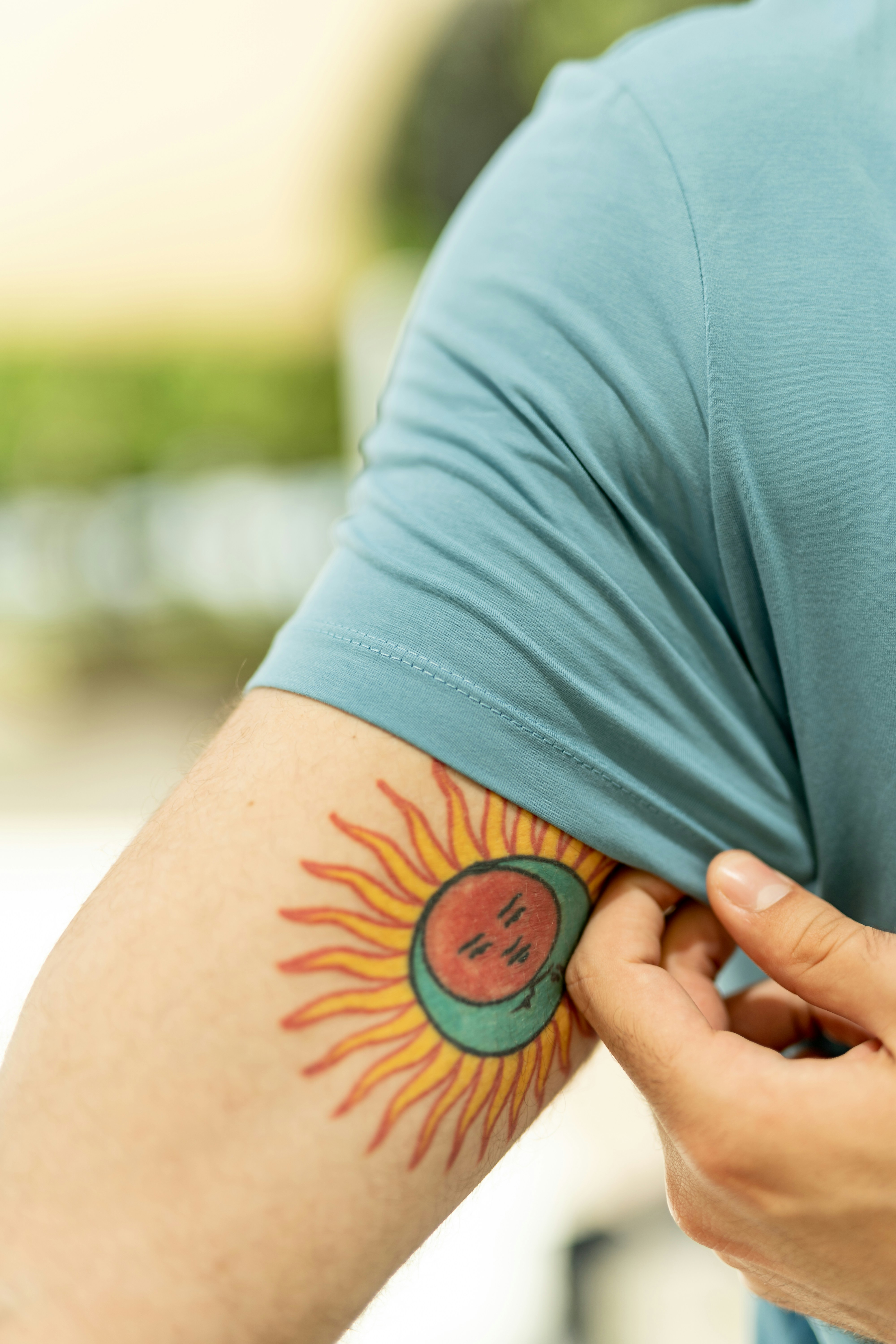 Sunburst Tattoo on Upper Arm Shows a Playful Ember