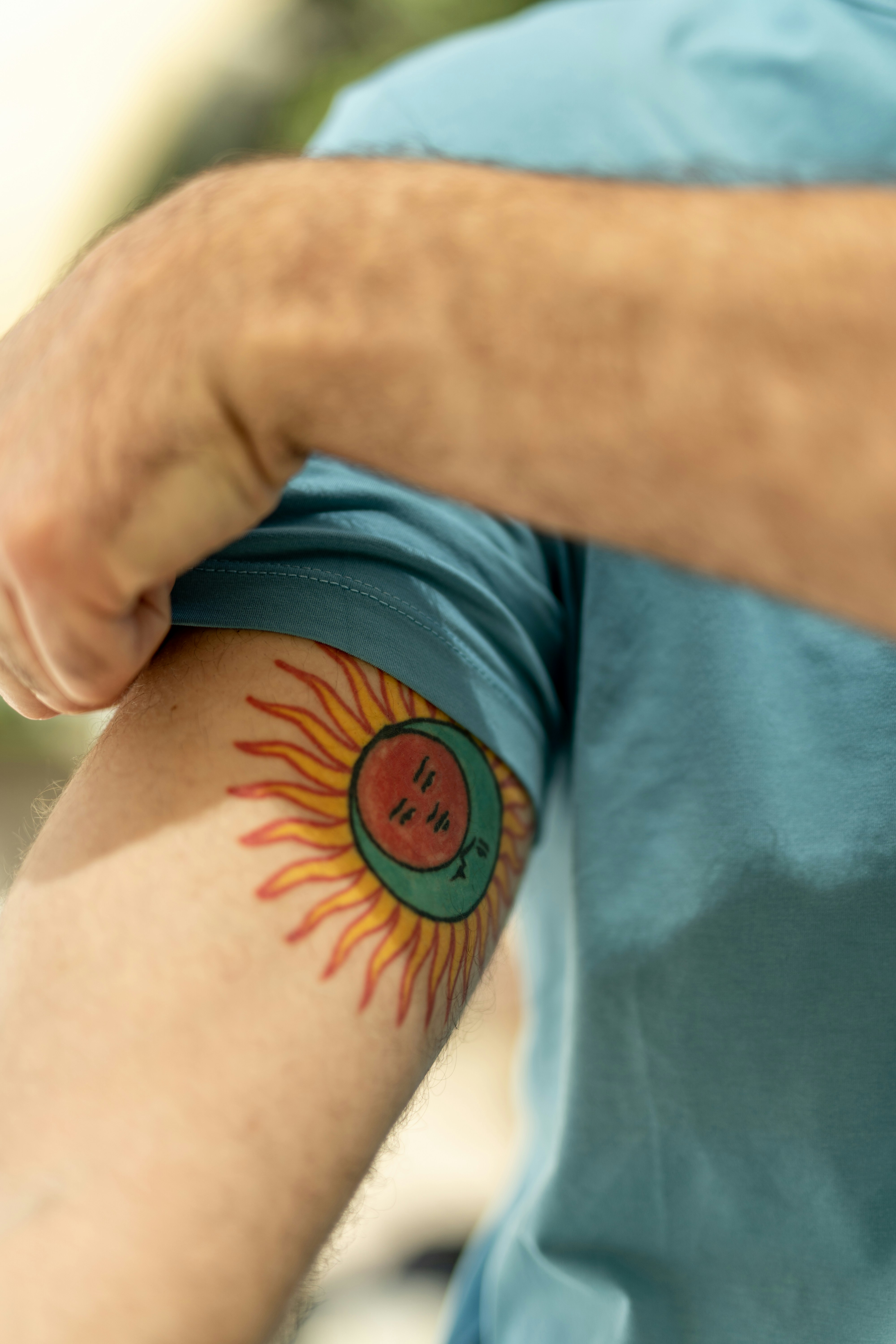 Sunburst Tattoo on Sunlit Arm: A Casual Moment