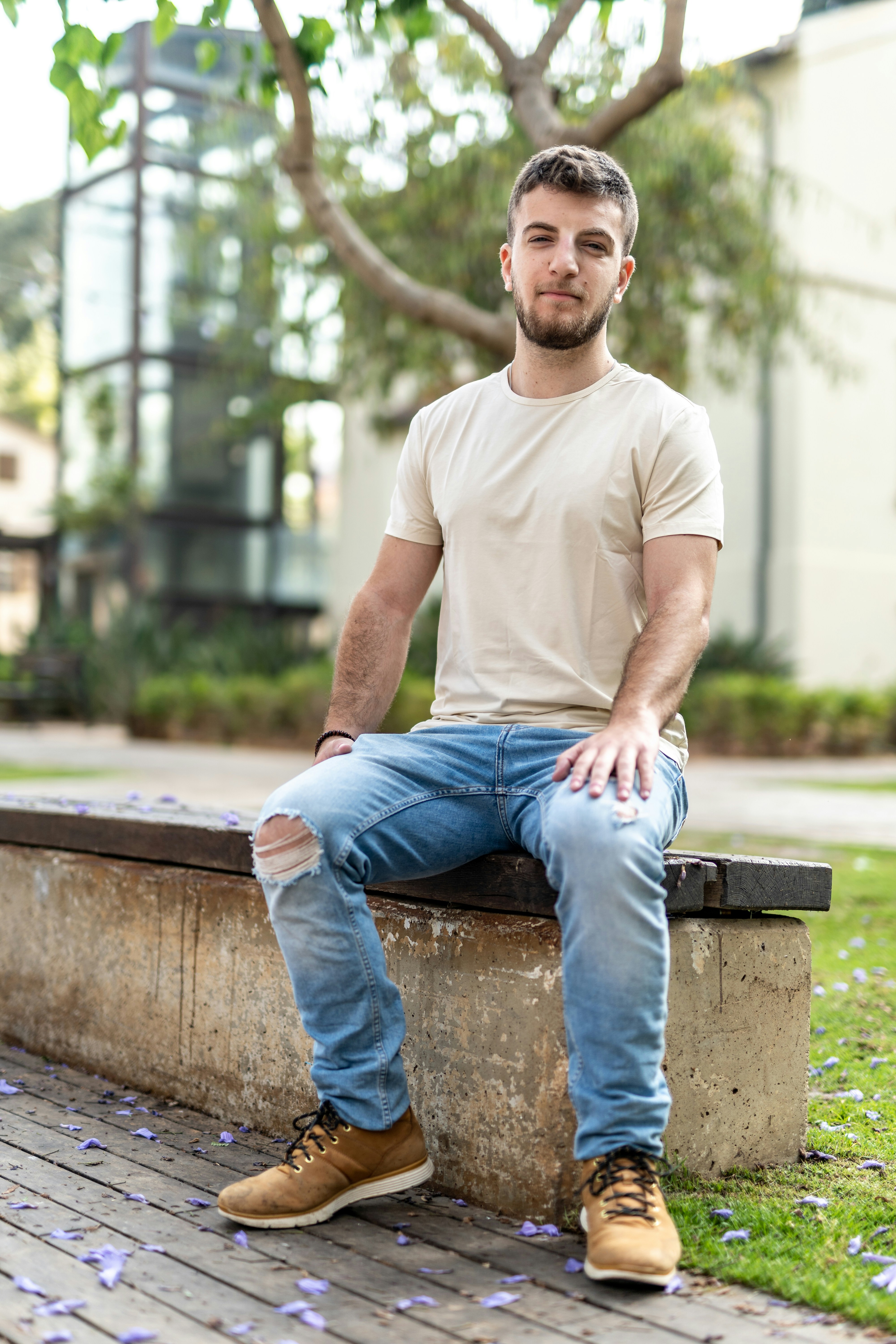 Un homme assis sur un banc dans un parc photo – Photo Vêtements ...