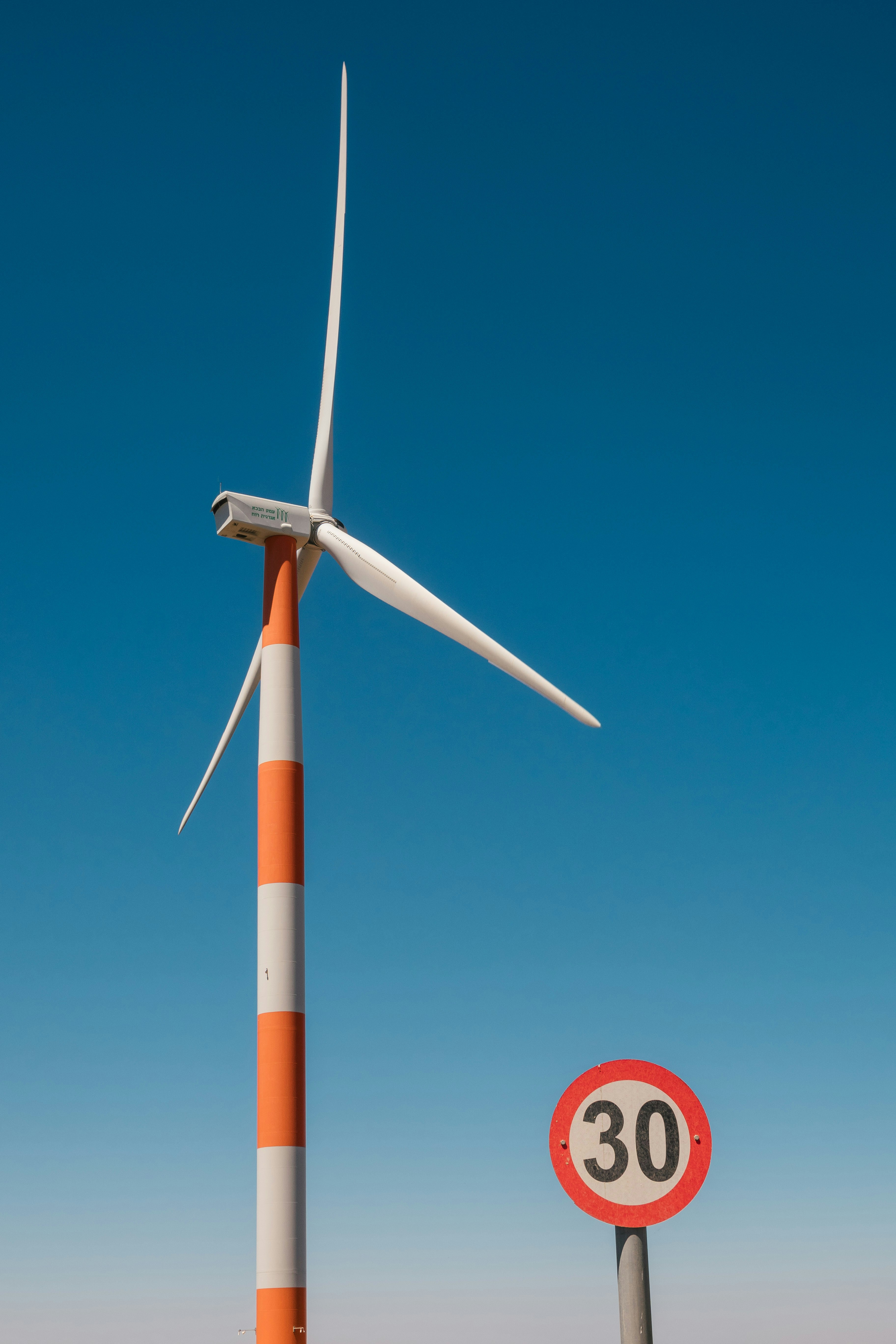 A wind turbine next to a speed limit sign photo – Free Blue Image on ...