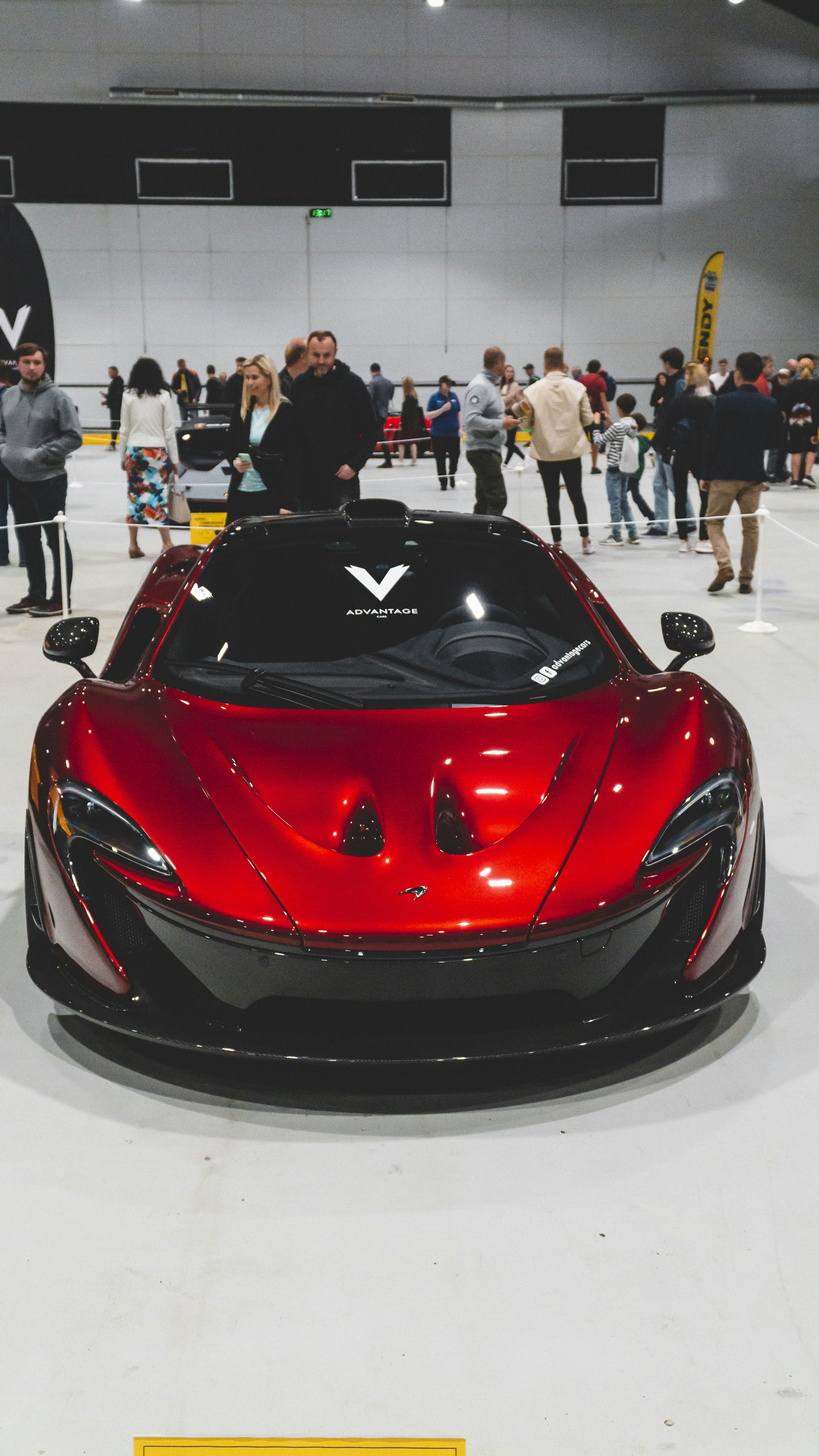 A red sports car on display at a car show photo – Free Mclaren p1 Image ...