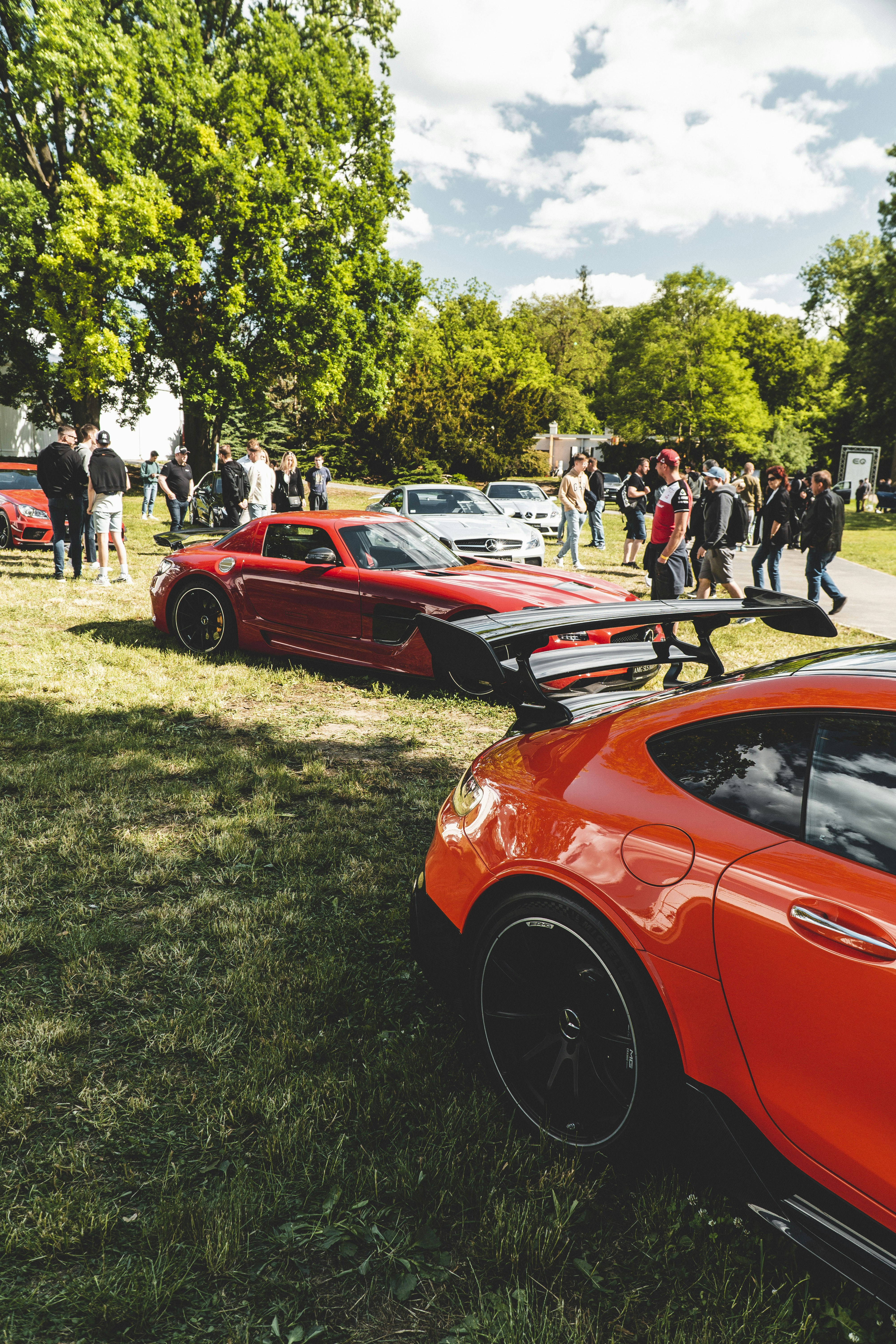 A group of cars parked next to each other on a lush green field photo ...