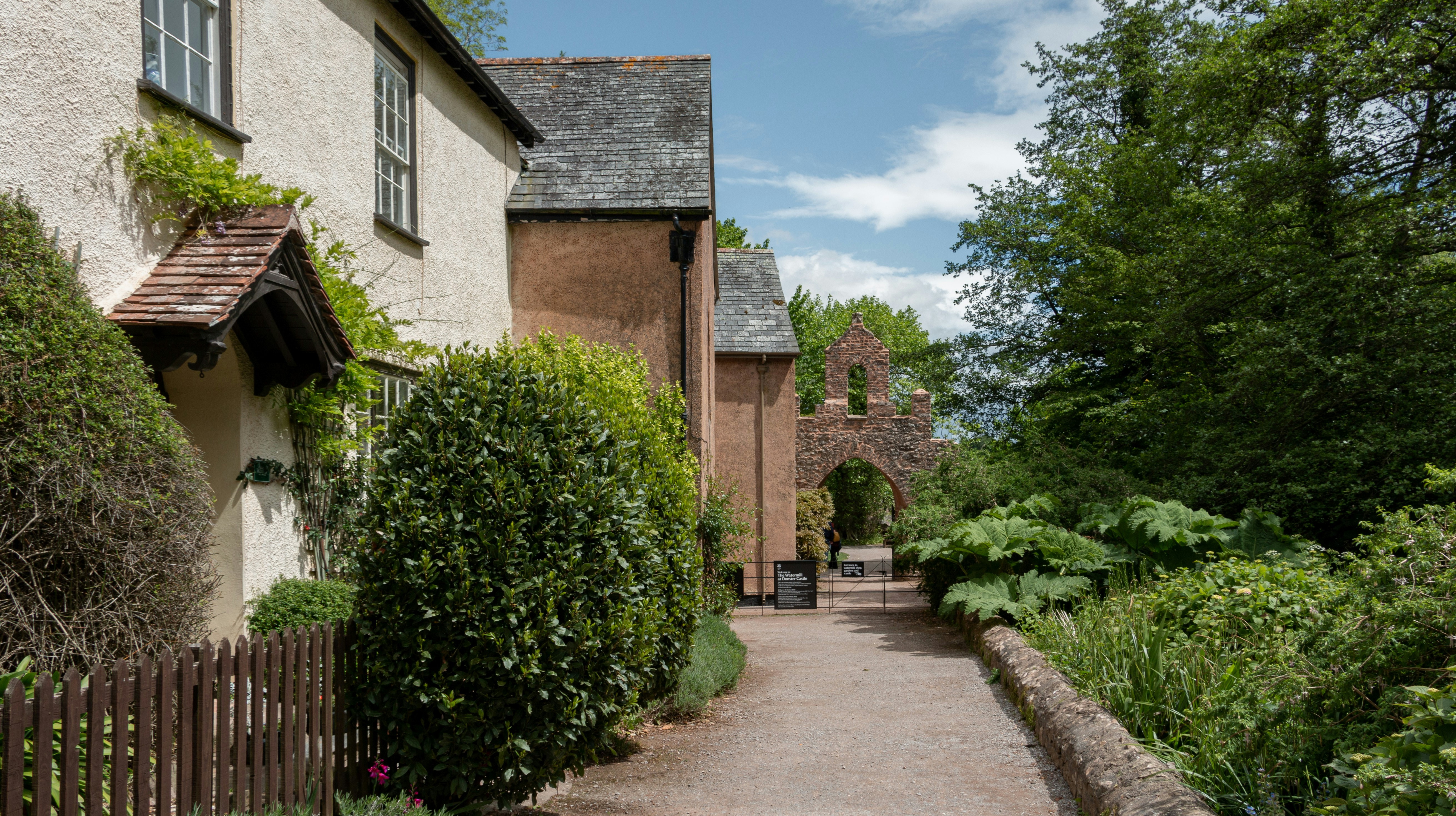 A pathway leading to a building with a gate photo – Free Dunster Image ...