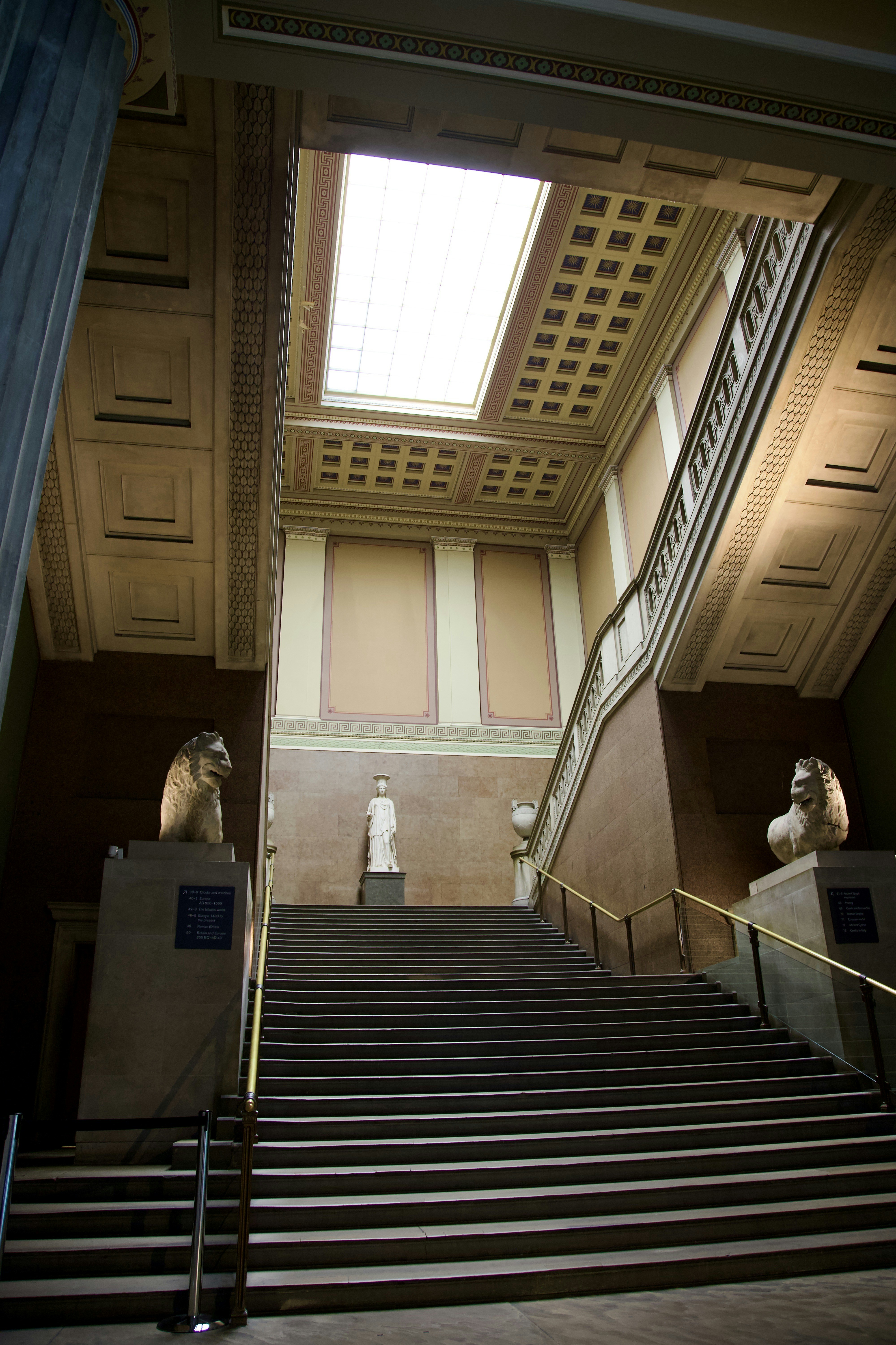 Central Atrium Stairs: Marble Steps Beneath a Glass Skylight, Guarded by Lion Statues