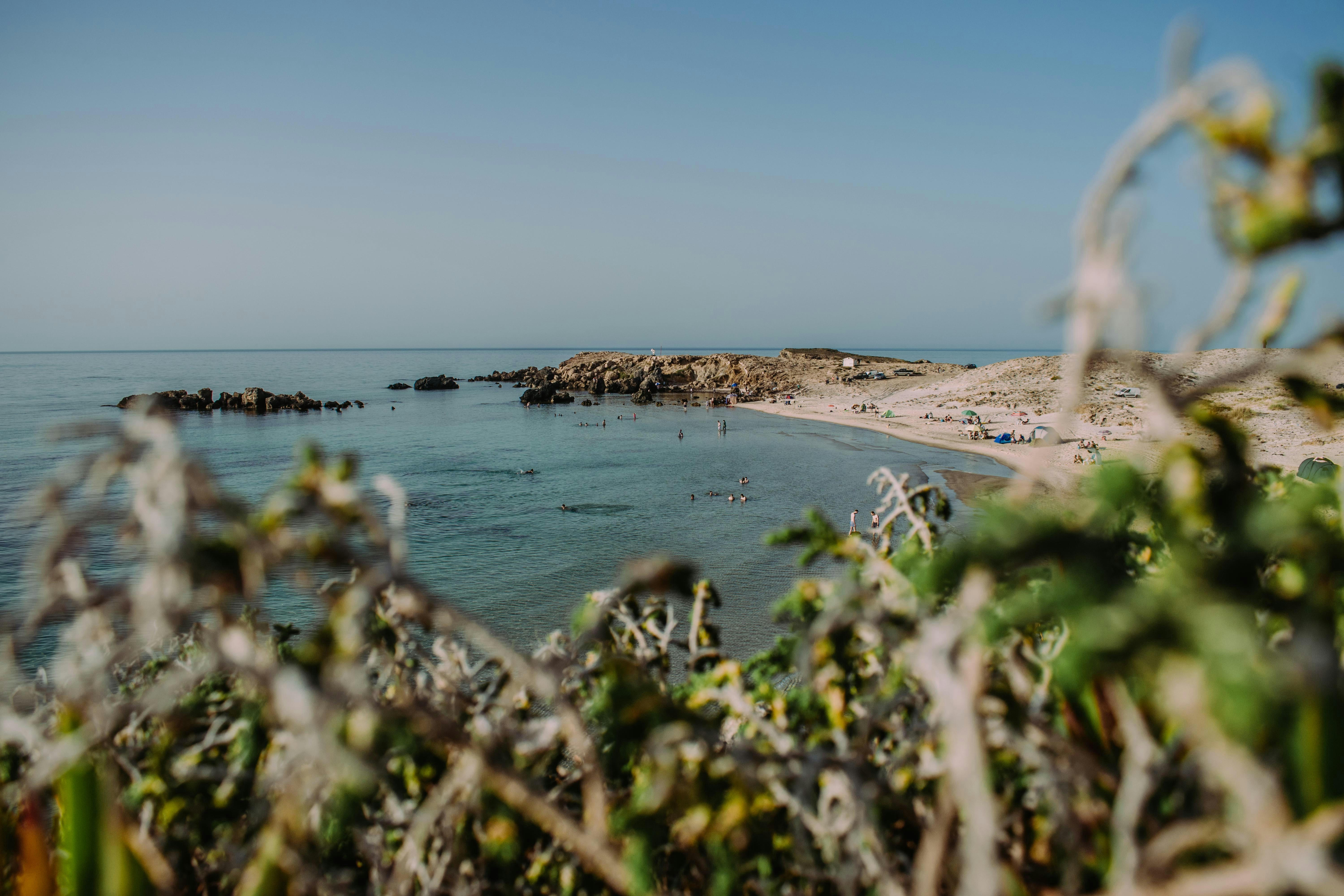 Foto Un cuerpo de agua rodeado por una playa de arena – Imagen Cap ...