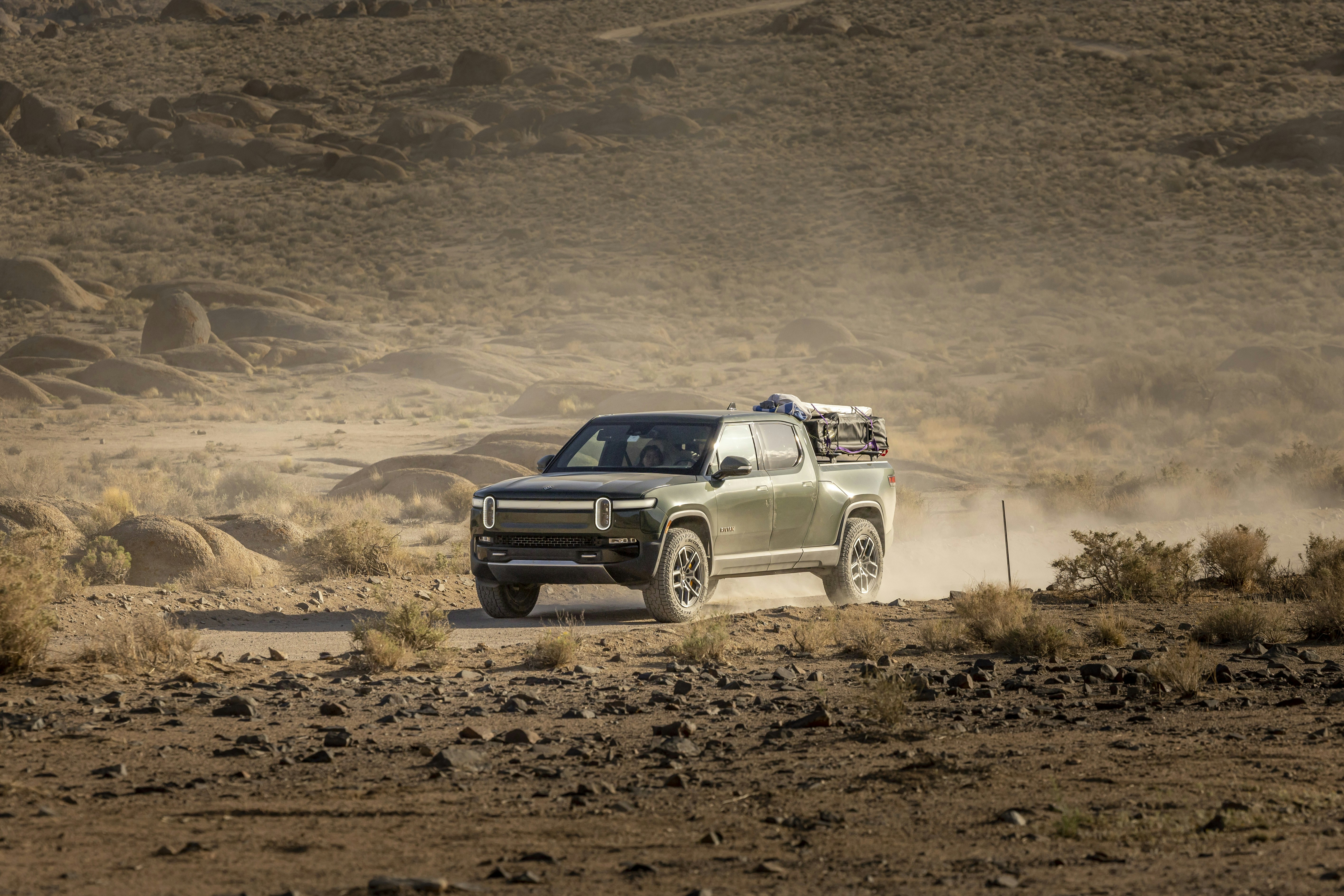 A truck driving down a dirt road in the desert photo – Free Rivian ...