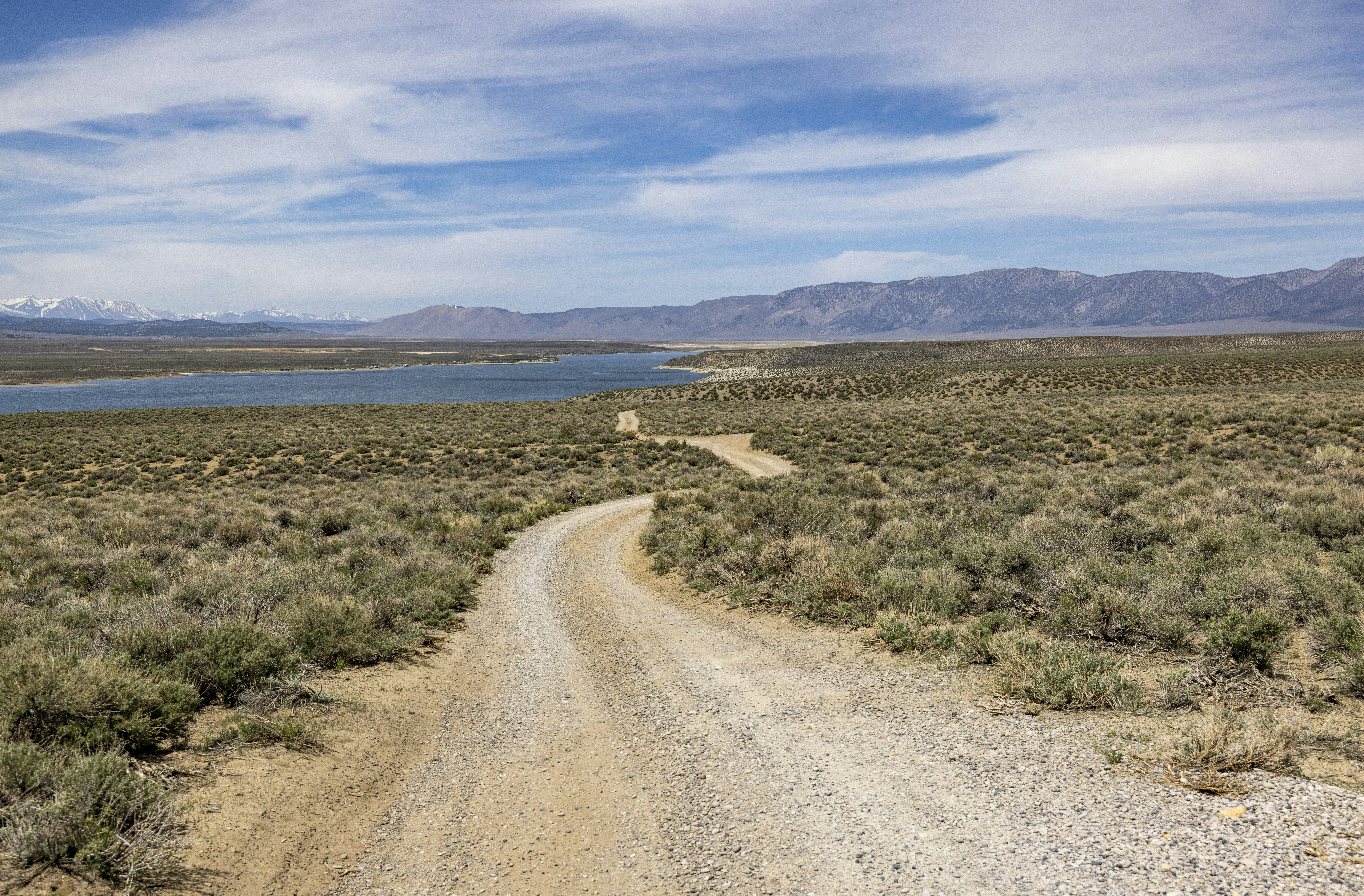 Un chemin de terre au milieu du désert photo – Photo Montagnes de la ...