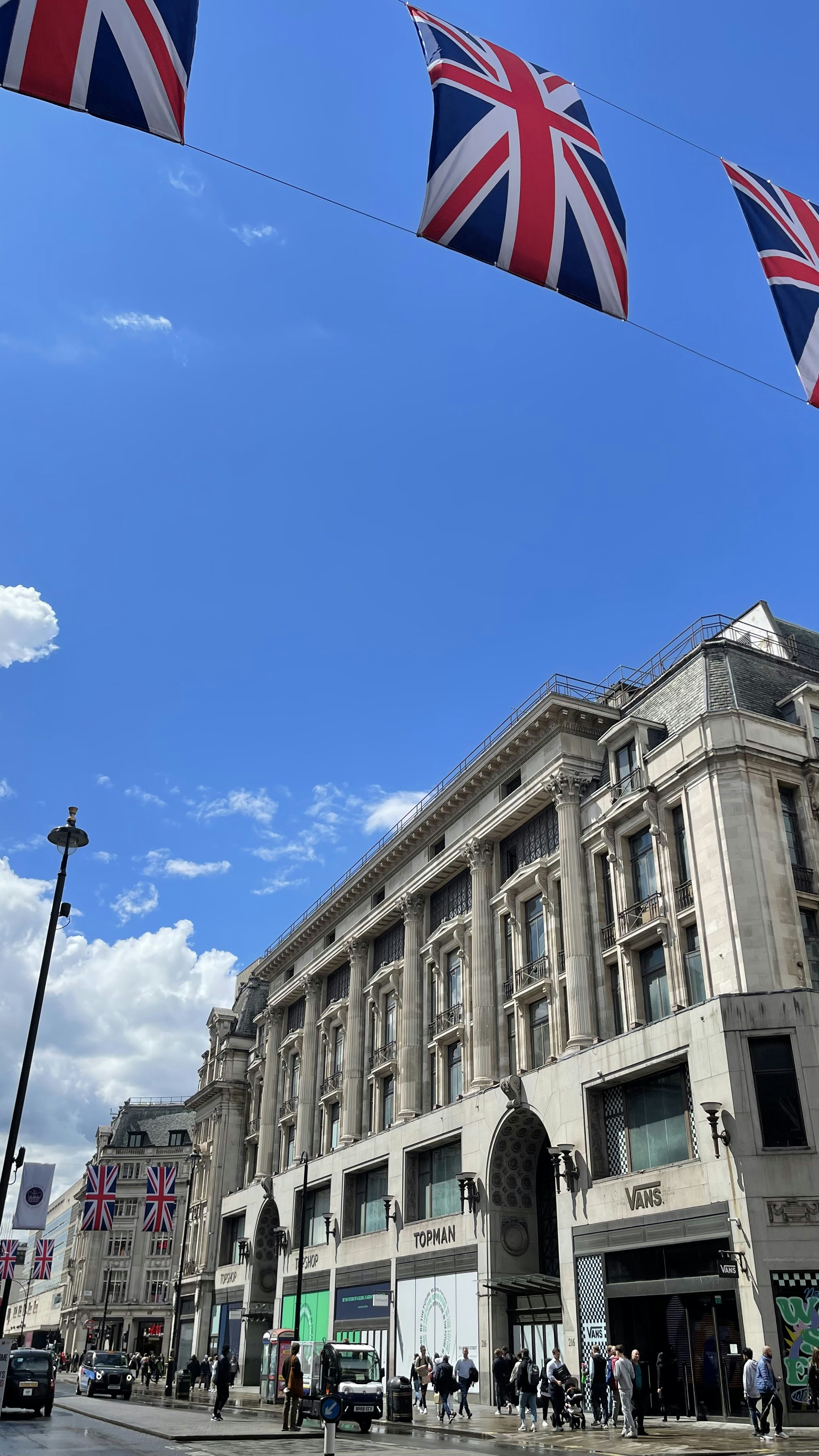 Union Flags Skim the Sky Over a Sunlit City Street of Historic Facades