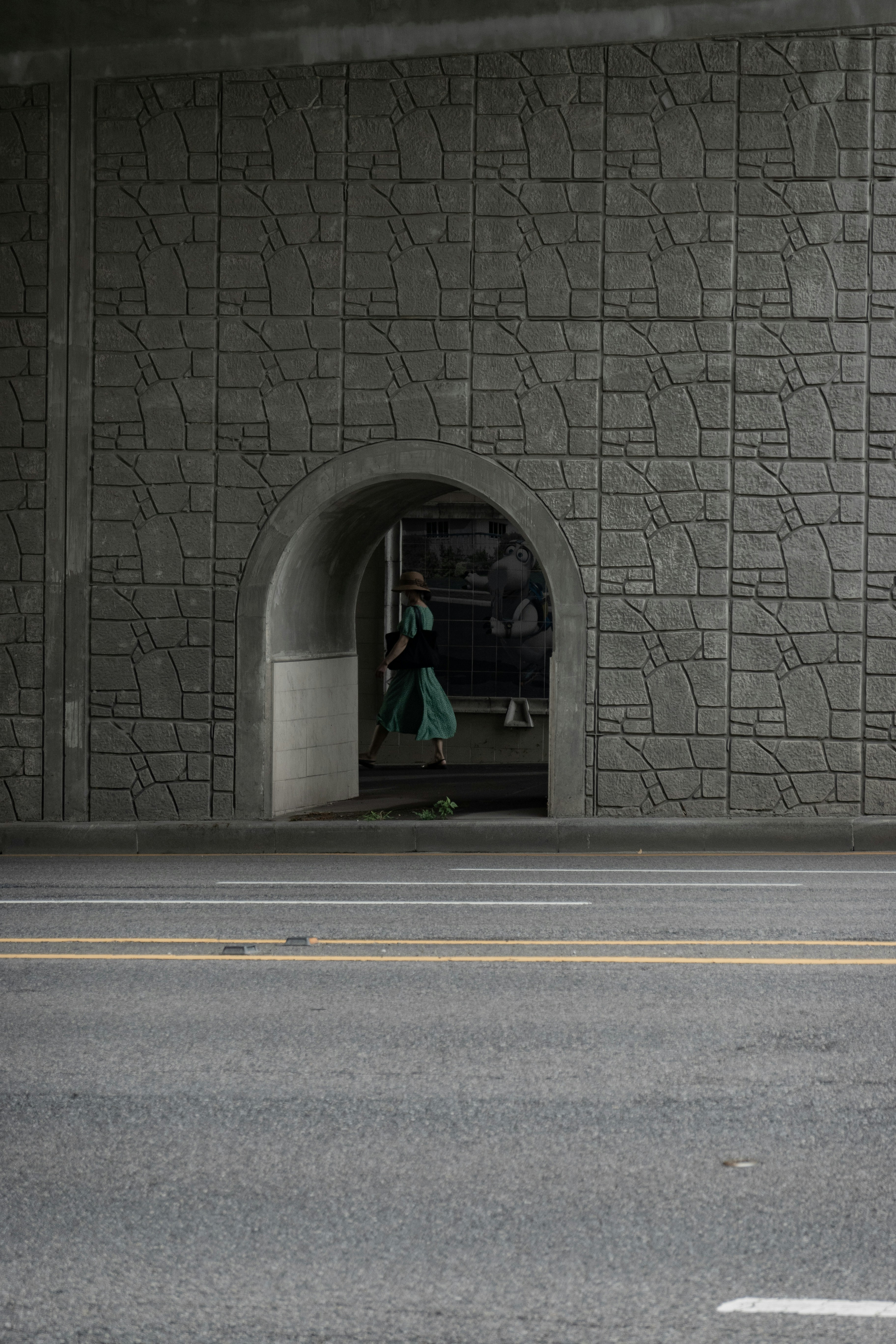 a man riding a skateboard down a street under a tunnel