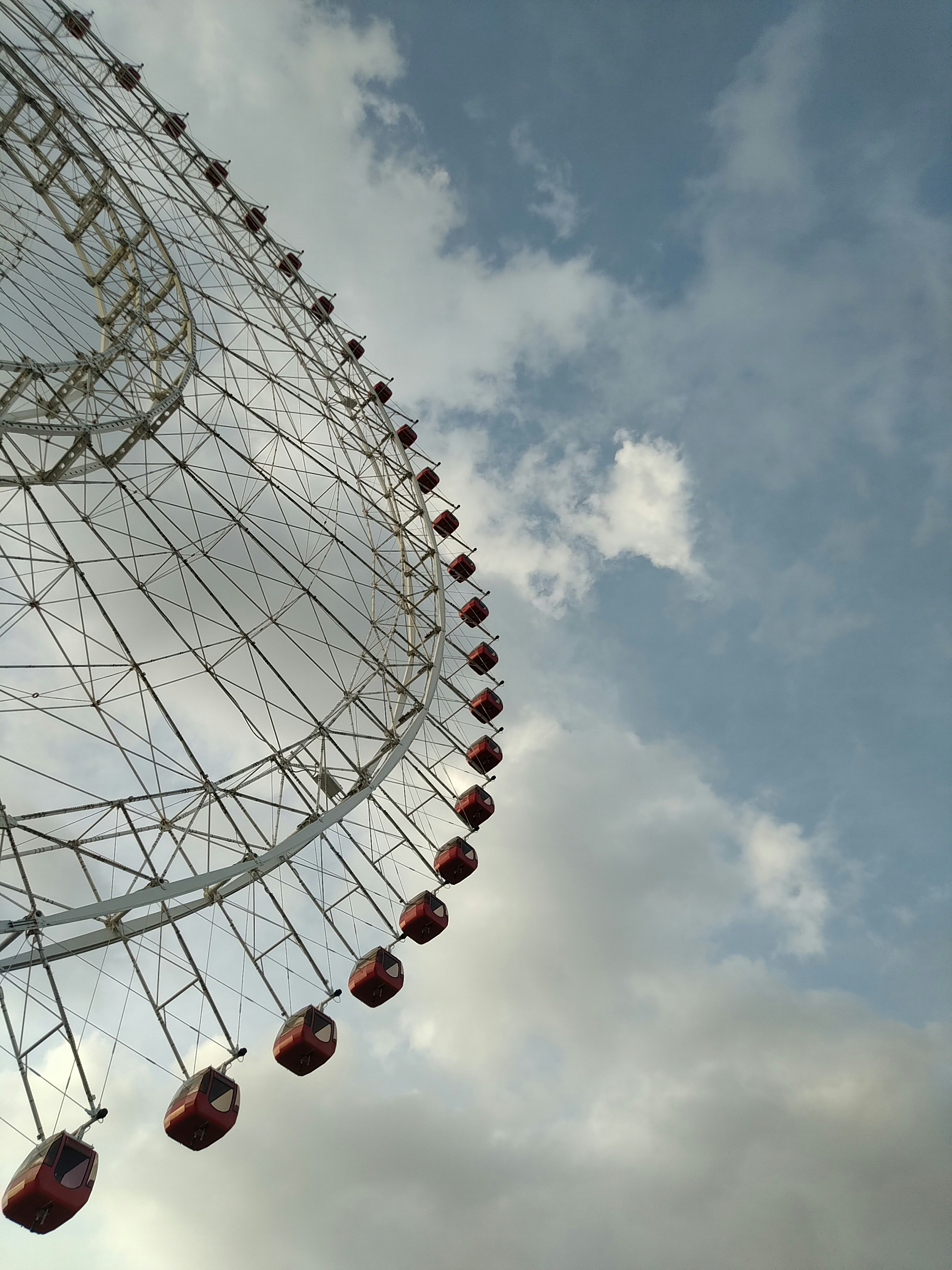 Ferris Wheel Silhouette: Cables Weave Through a Sky of Clouds