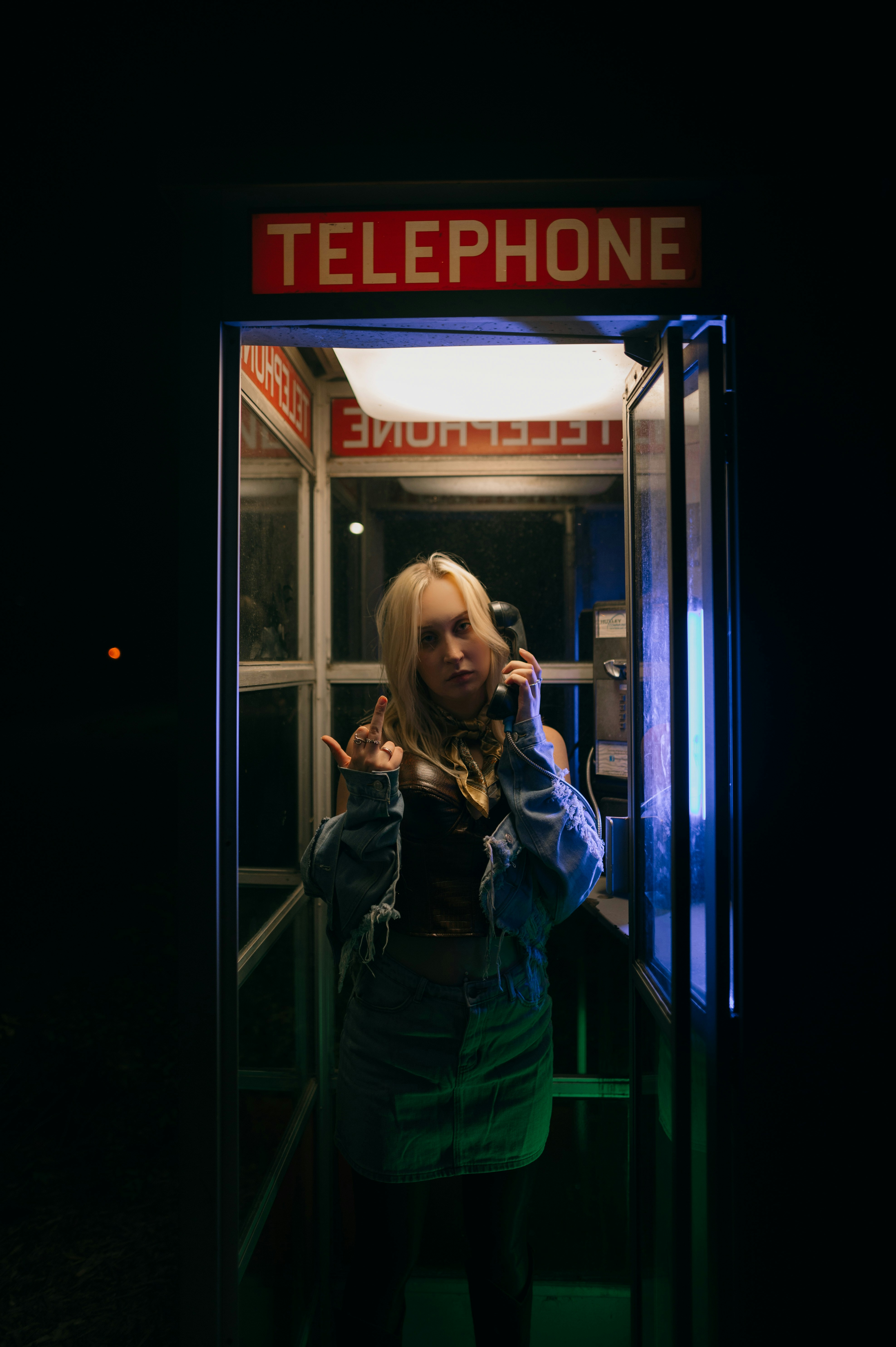 a woman standing in front of a telephone booth