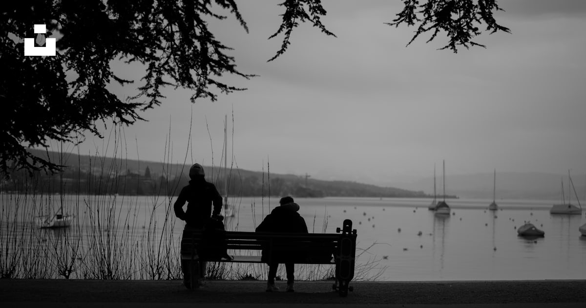 Deux Personnes Assises Sur Un Banc Près Dun Plan Deau Photo Photo