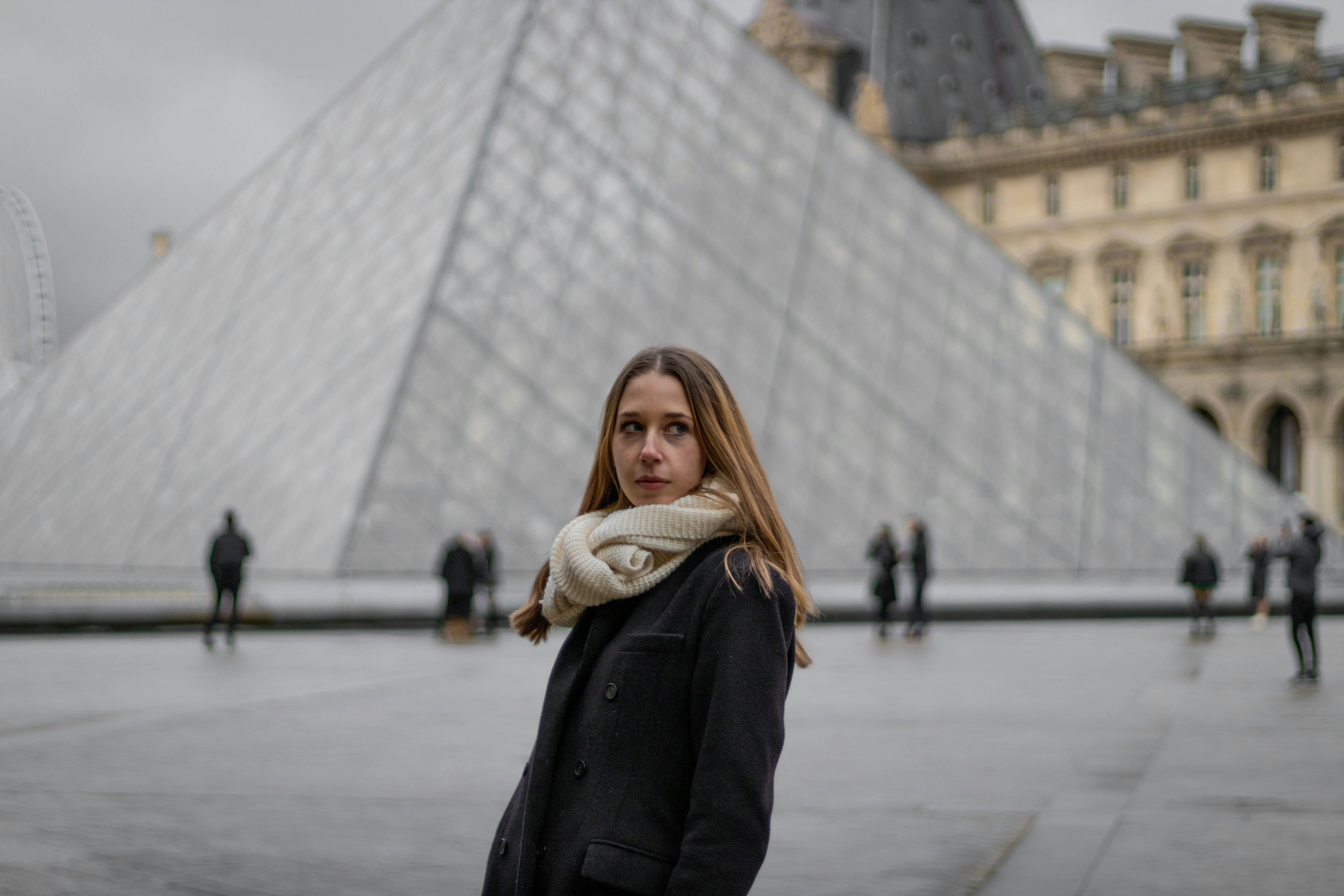 Model girl in front of the Louvre museum pyramid in Paris, France.