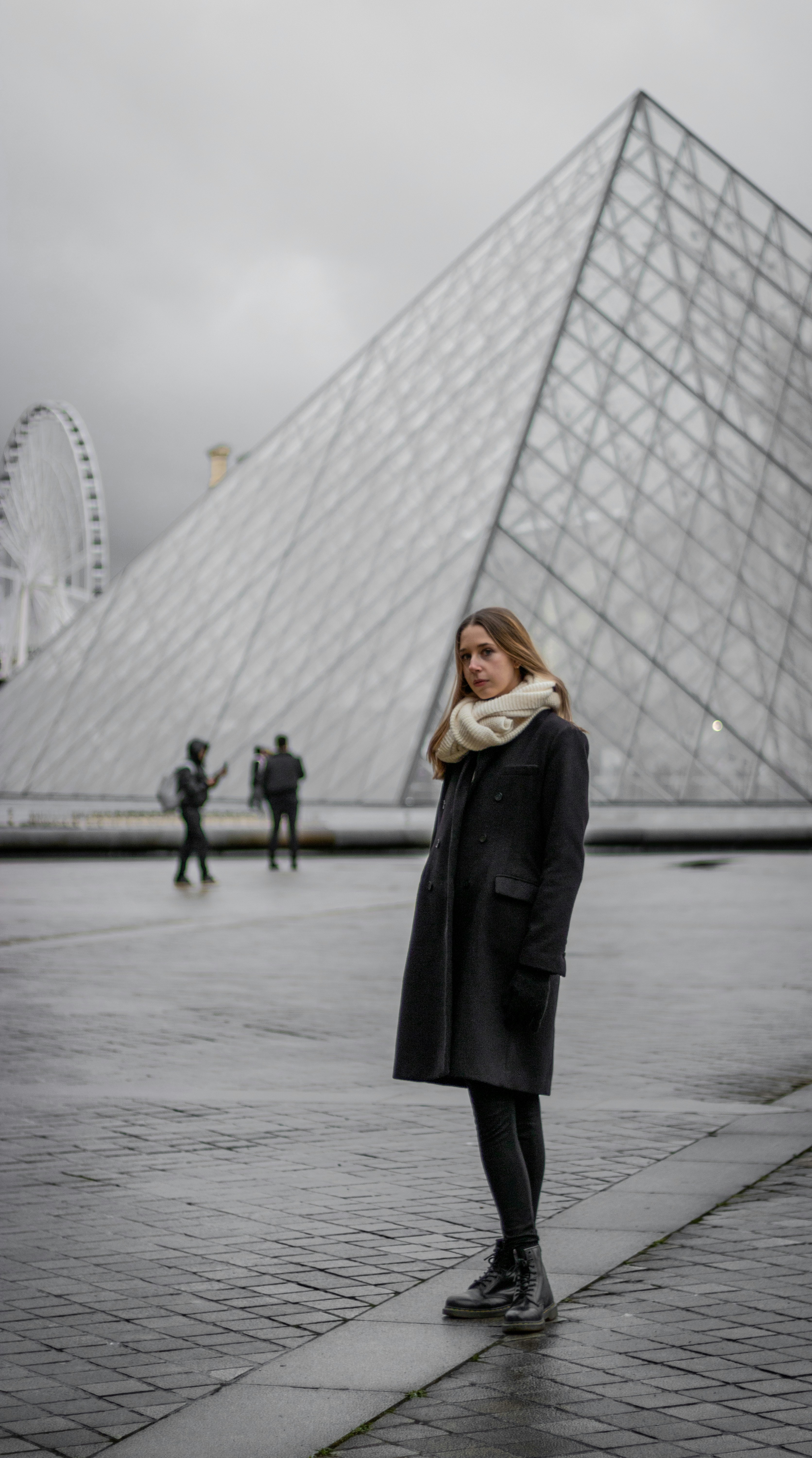 Model girl in front of the Louvre museum pyramid in Paris, France.
