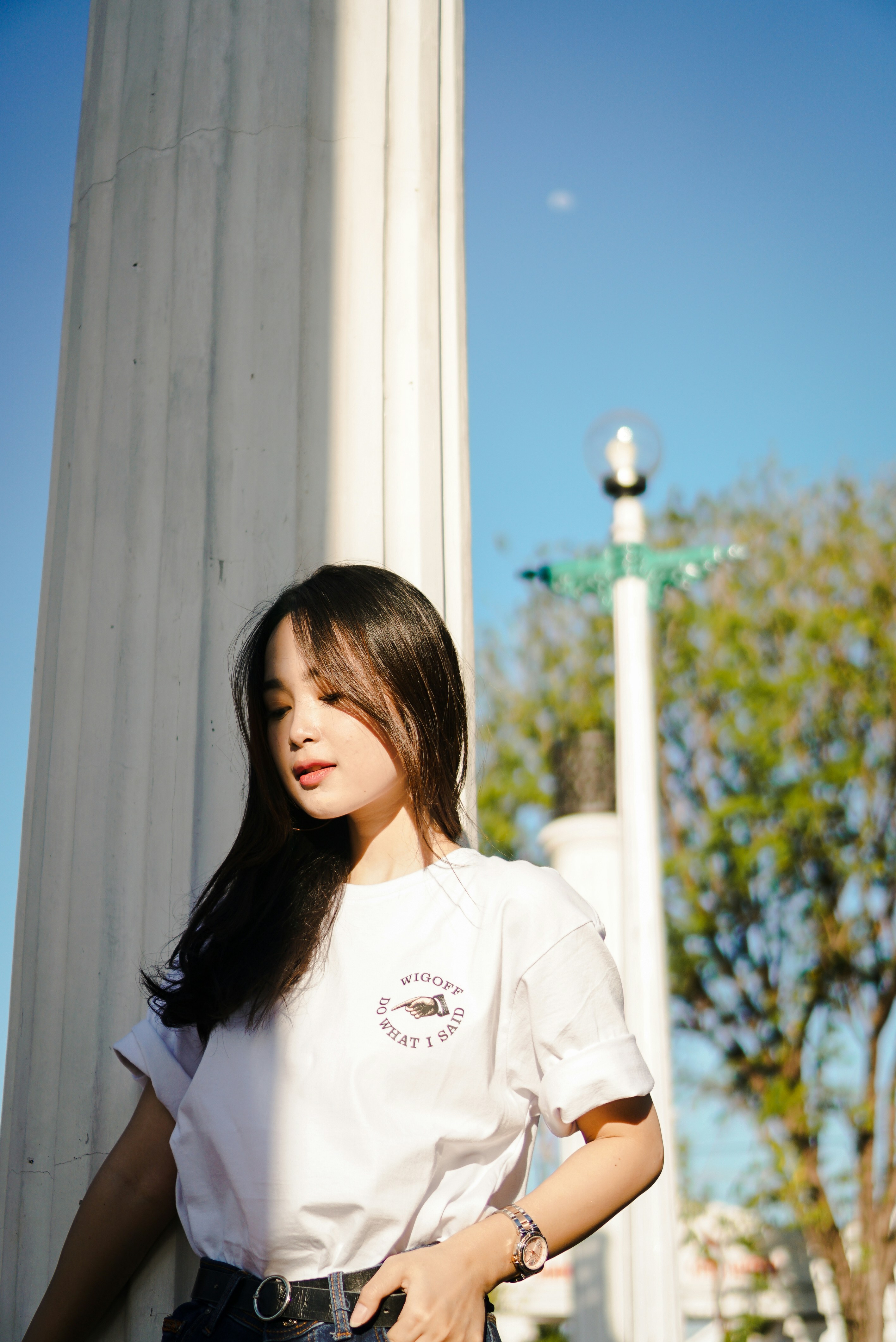 a woman standing next to a tall white column