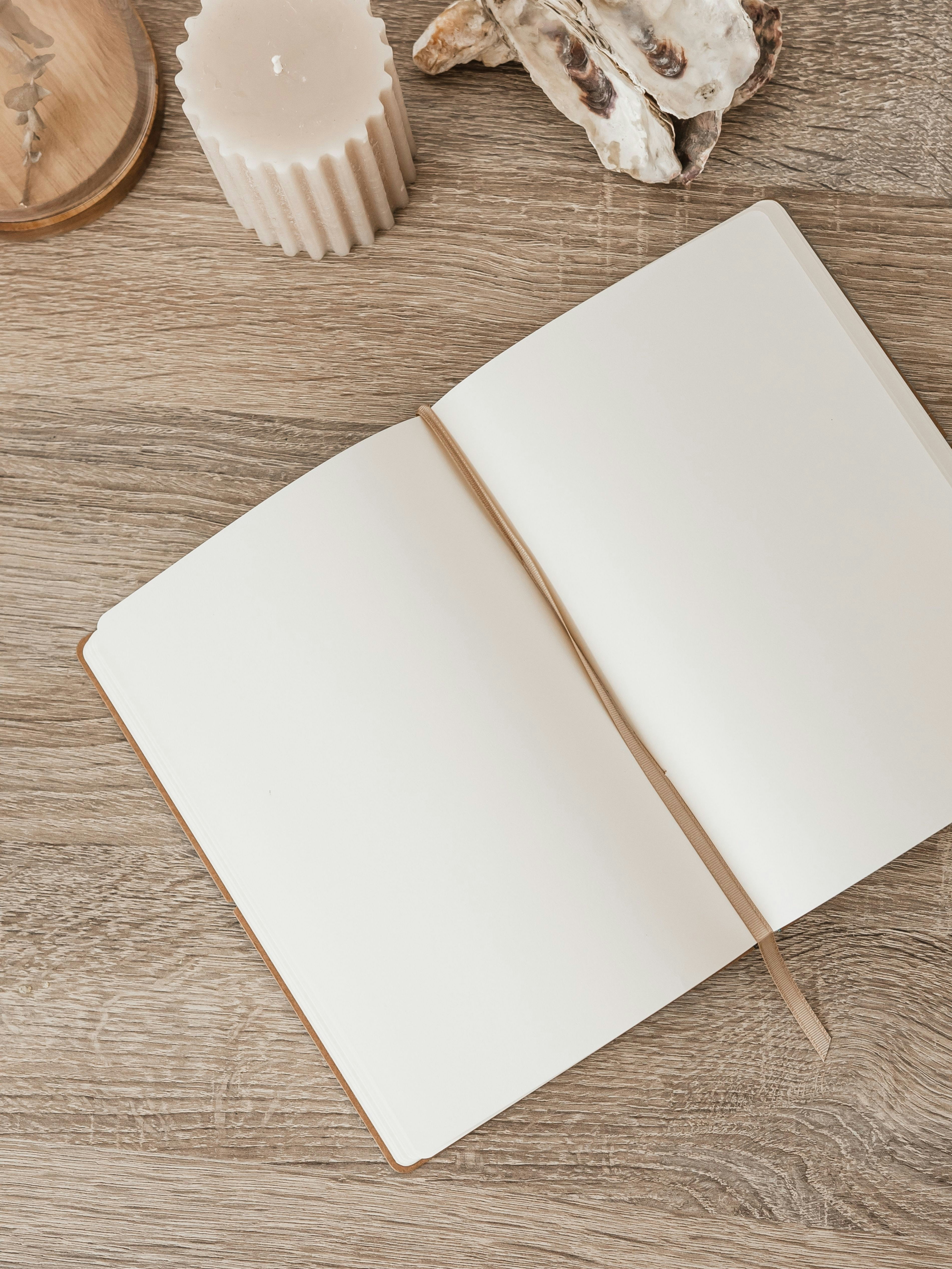 An open notebook sitting on top of a wooden table photo – Free Writing ...