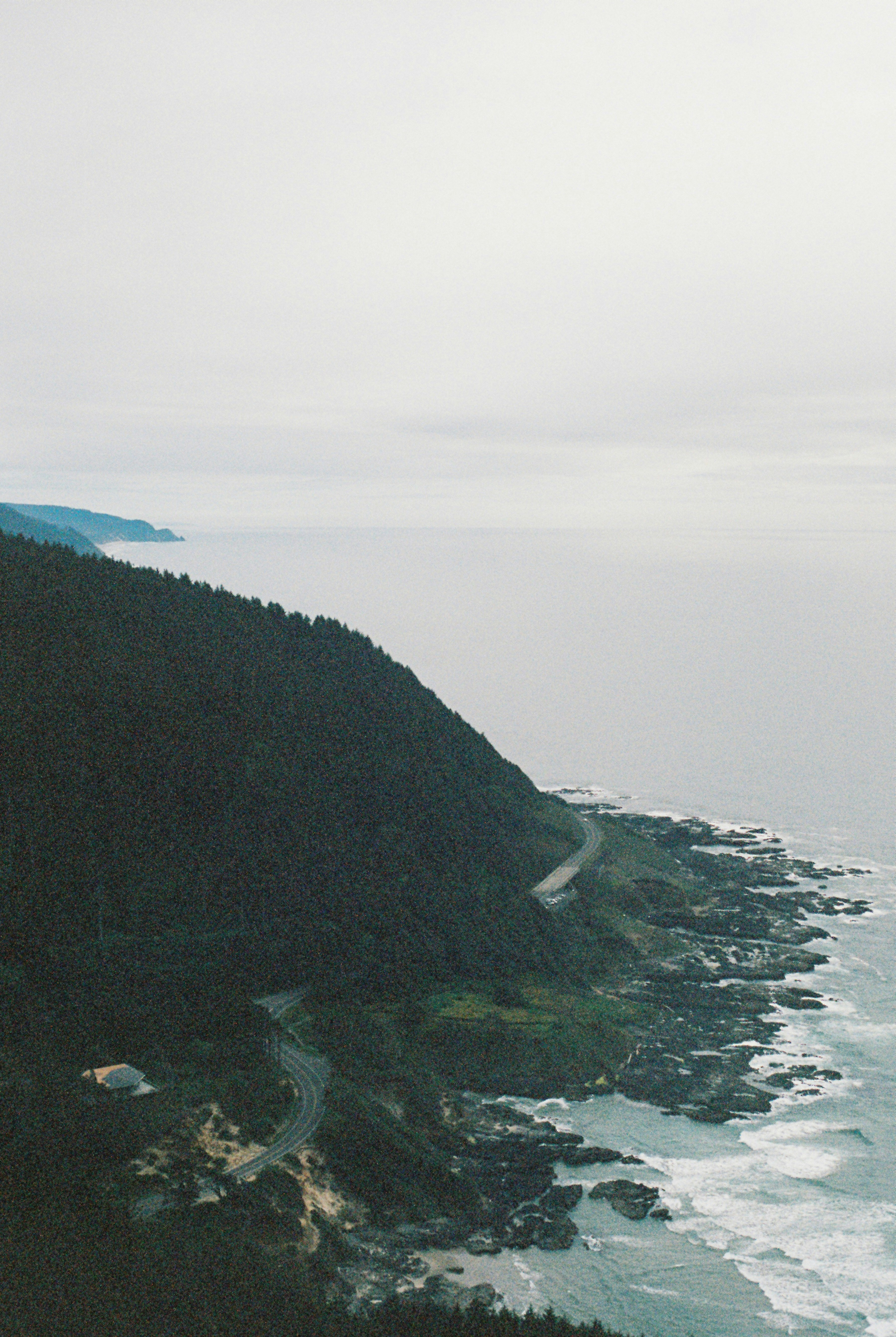 Coastal Ribbon: Aerial View of a Winding Road Along Emerald Cliffs