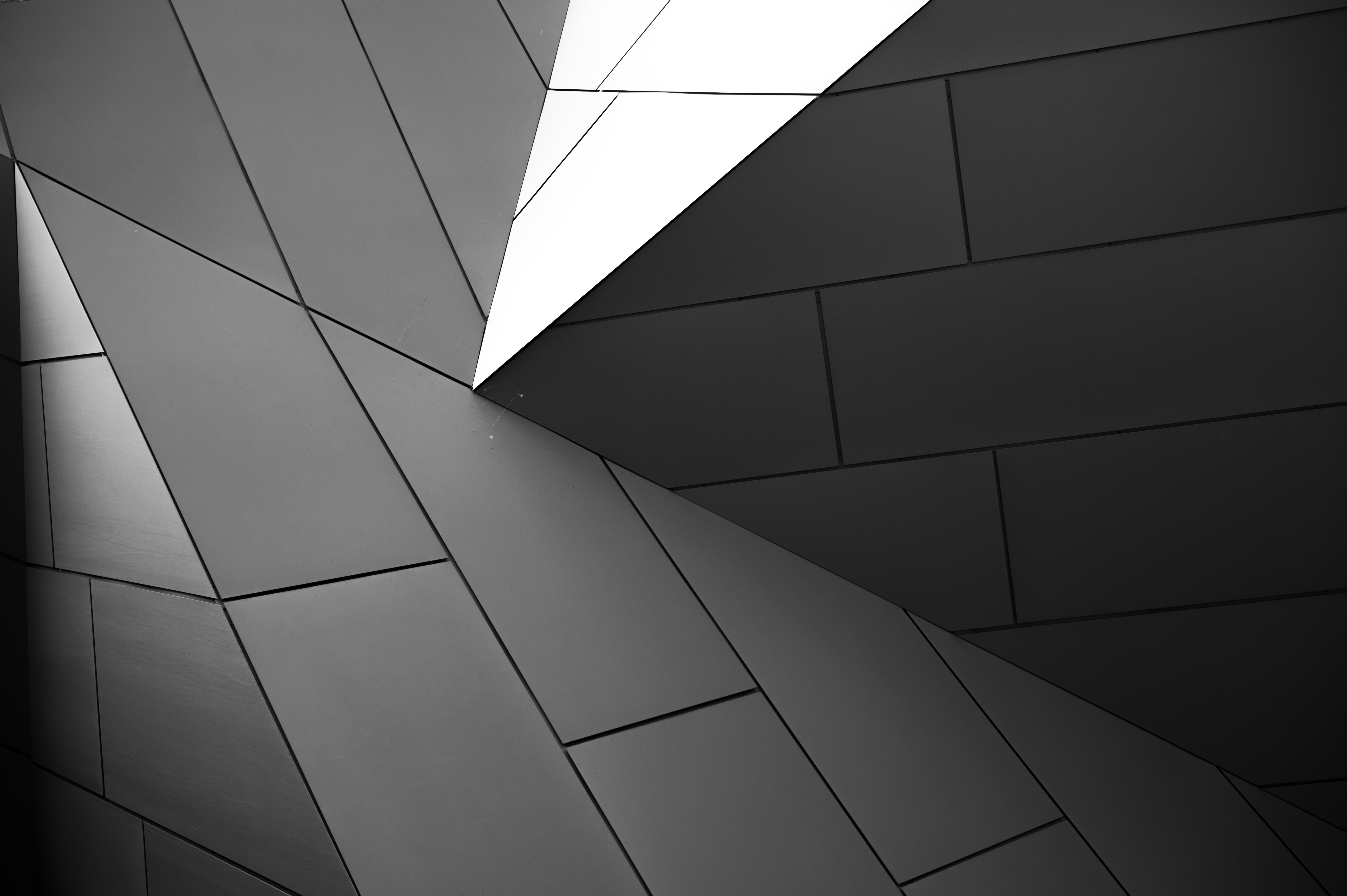 Geometric arrangement of angular surfaces creating a dynamic interplay of light and shadow in a monochromatic setting.