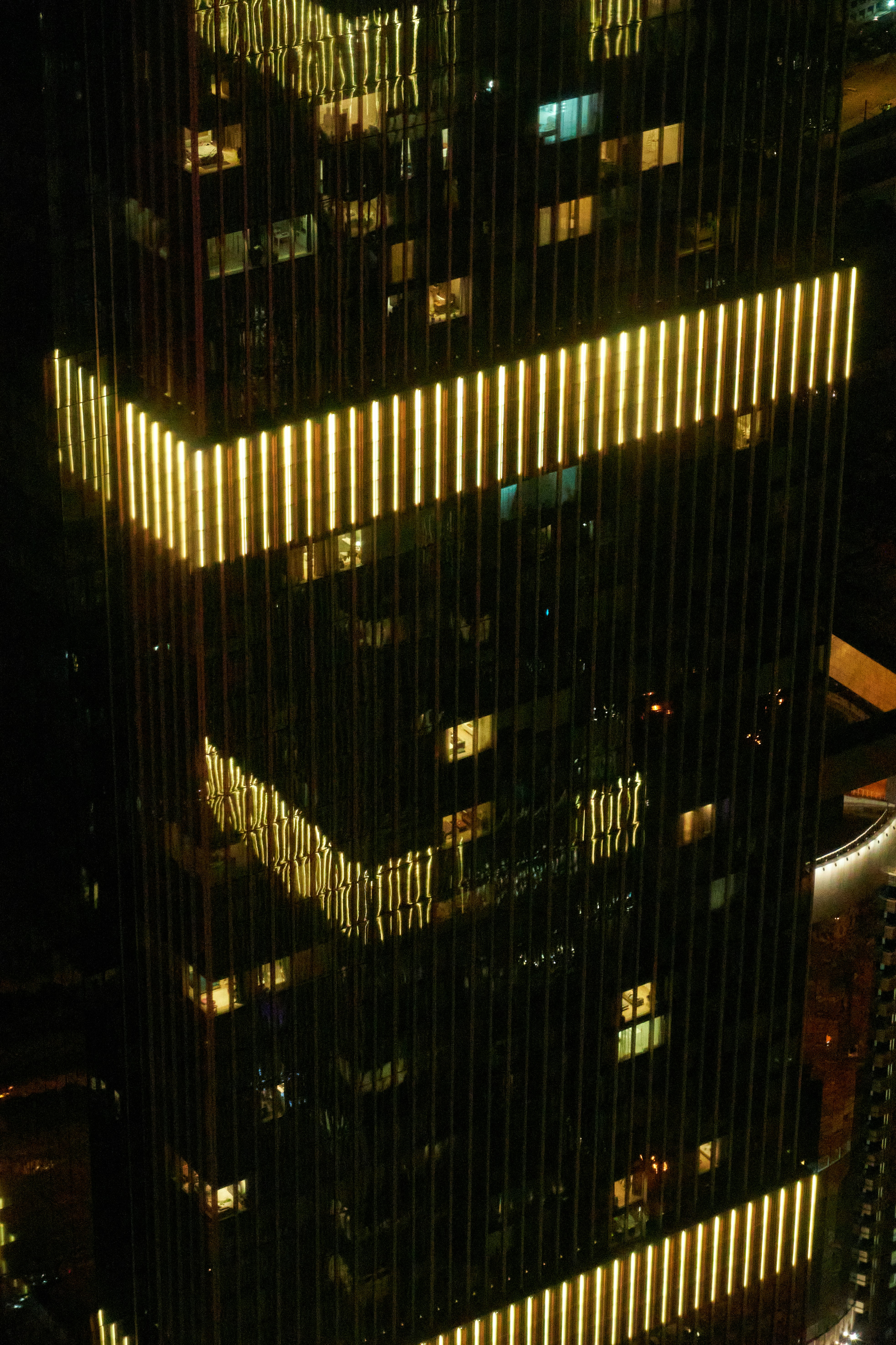 A very tall building lit up at night photo – Free Brown Image on Unsplash