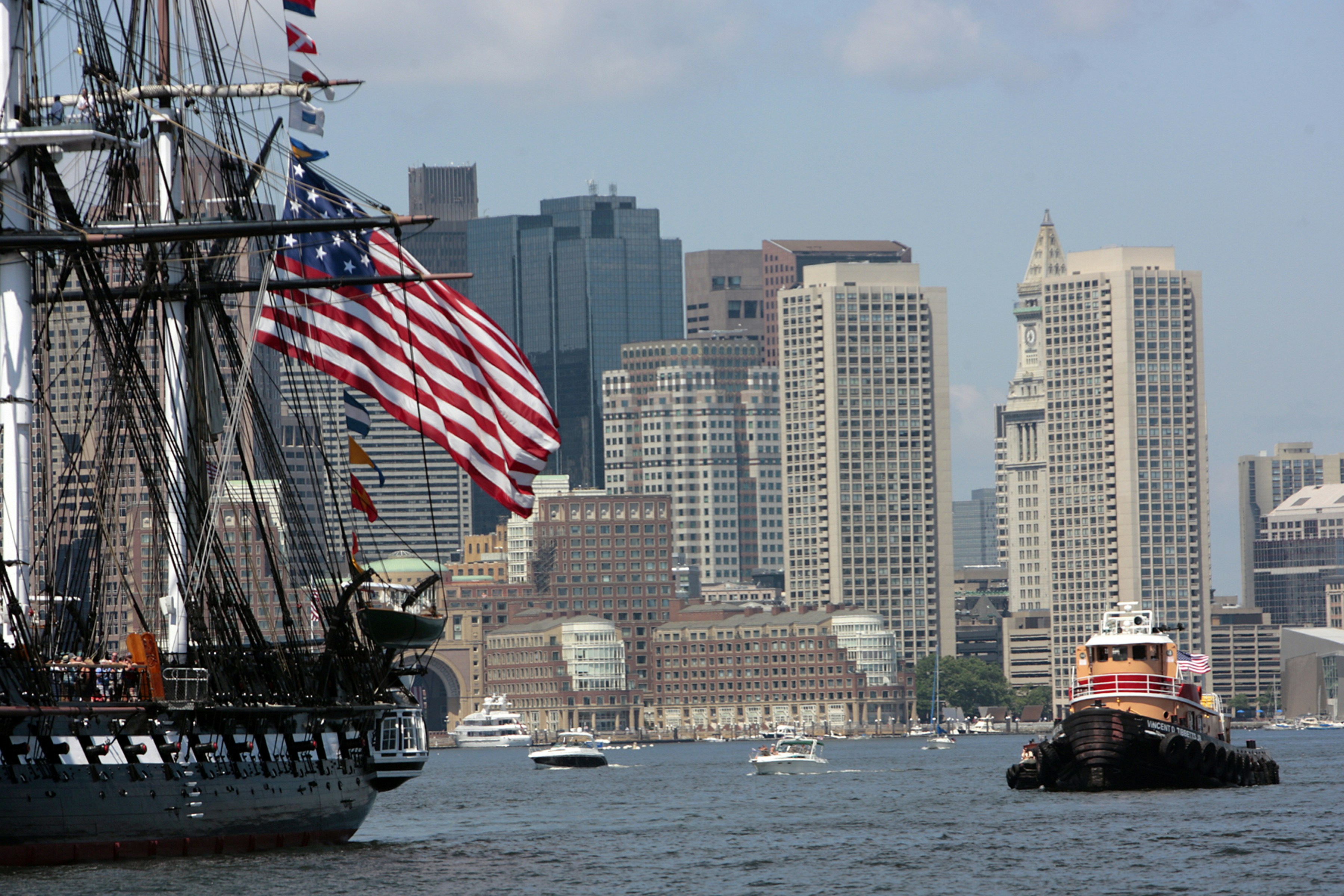 a large boat in a body of water with a city in the background