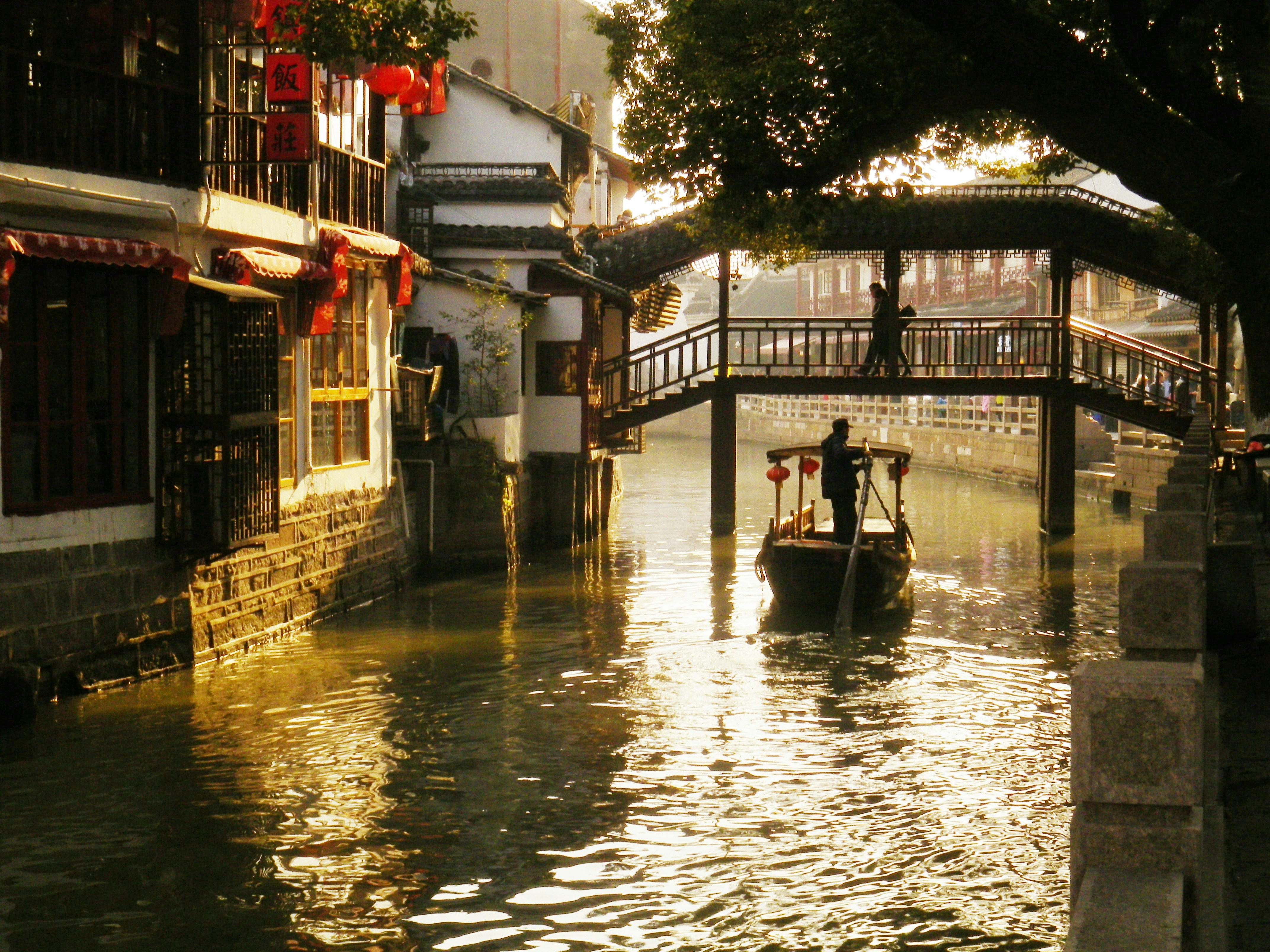 A couple of boats floating down a river under a bridge photo – Free ...