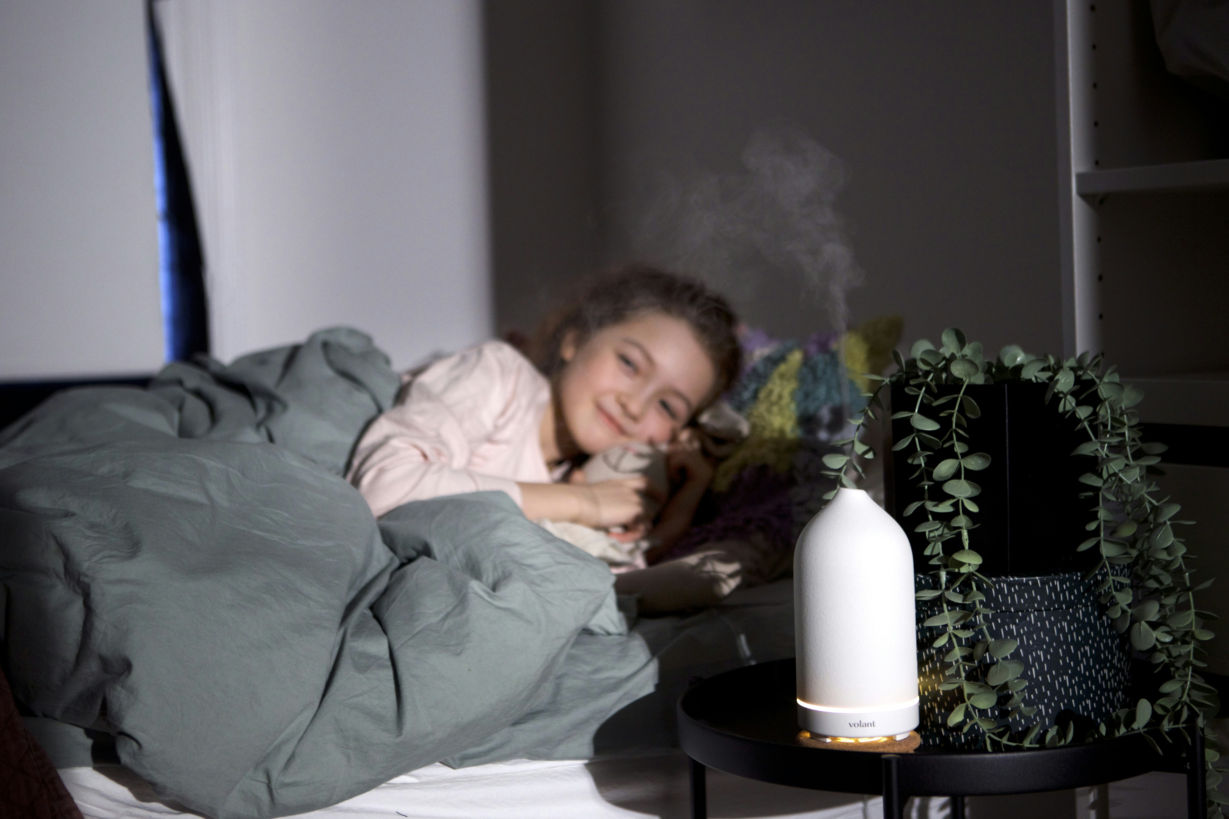 A girl is laying in bed with a humidifier photo – Free Portrait Image ...