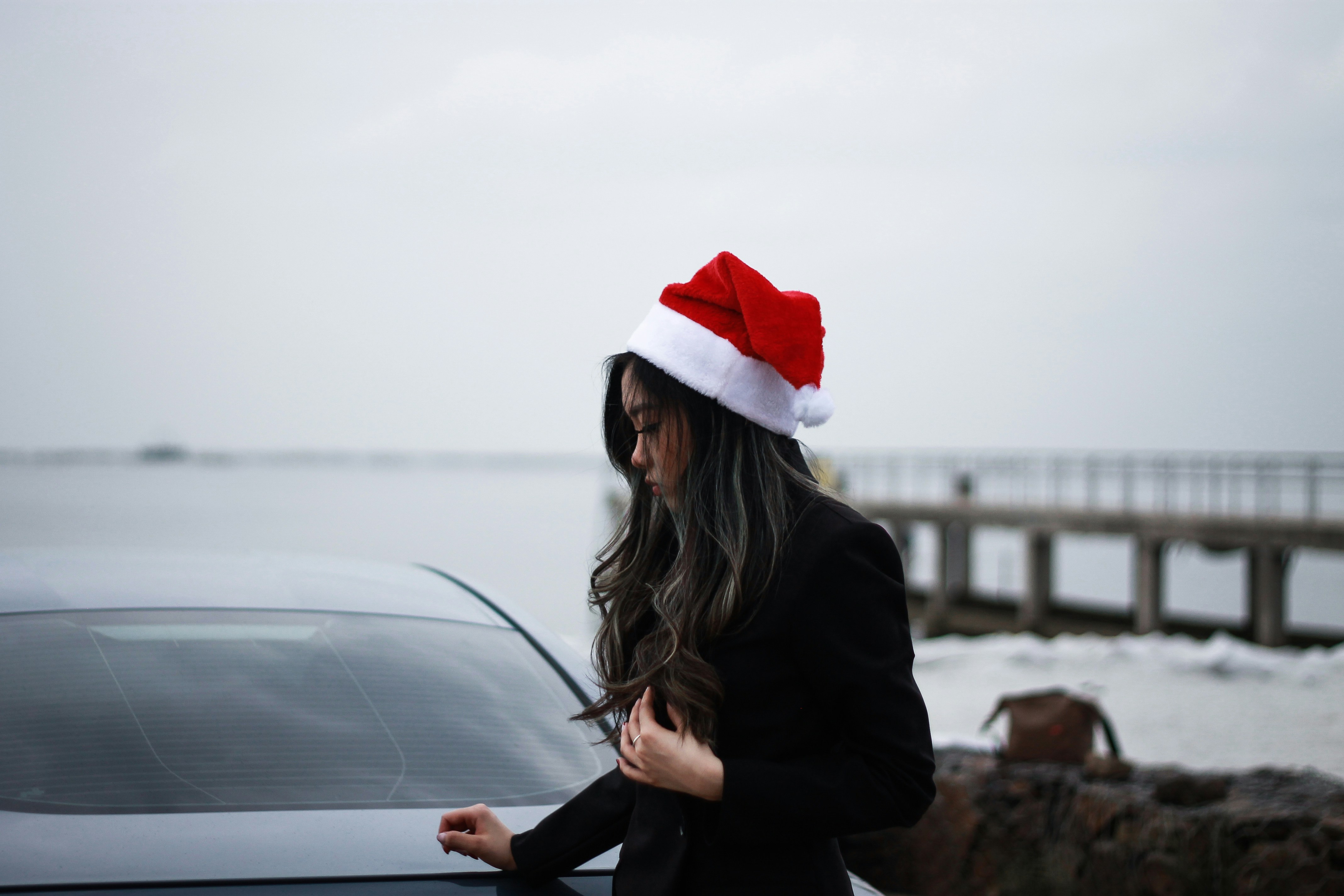 Red Santa Hat by the Seaside: A Quiet Portrait by the Pier