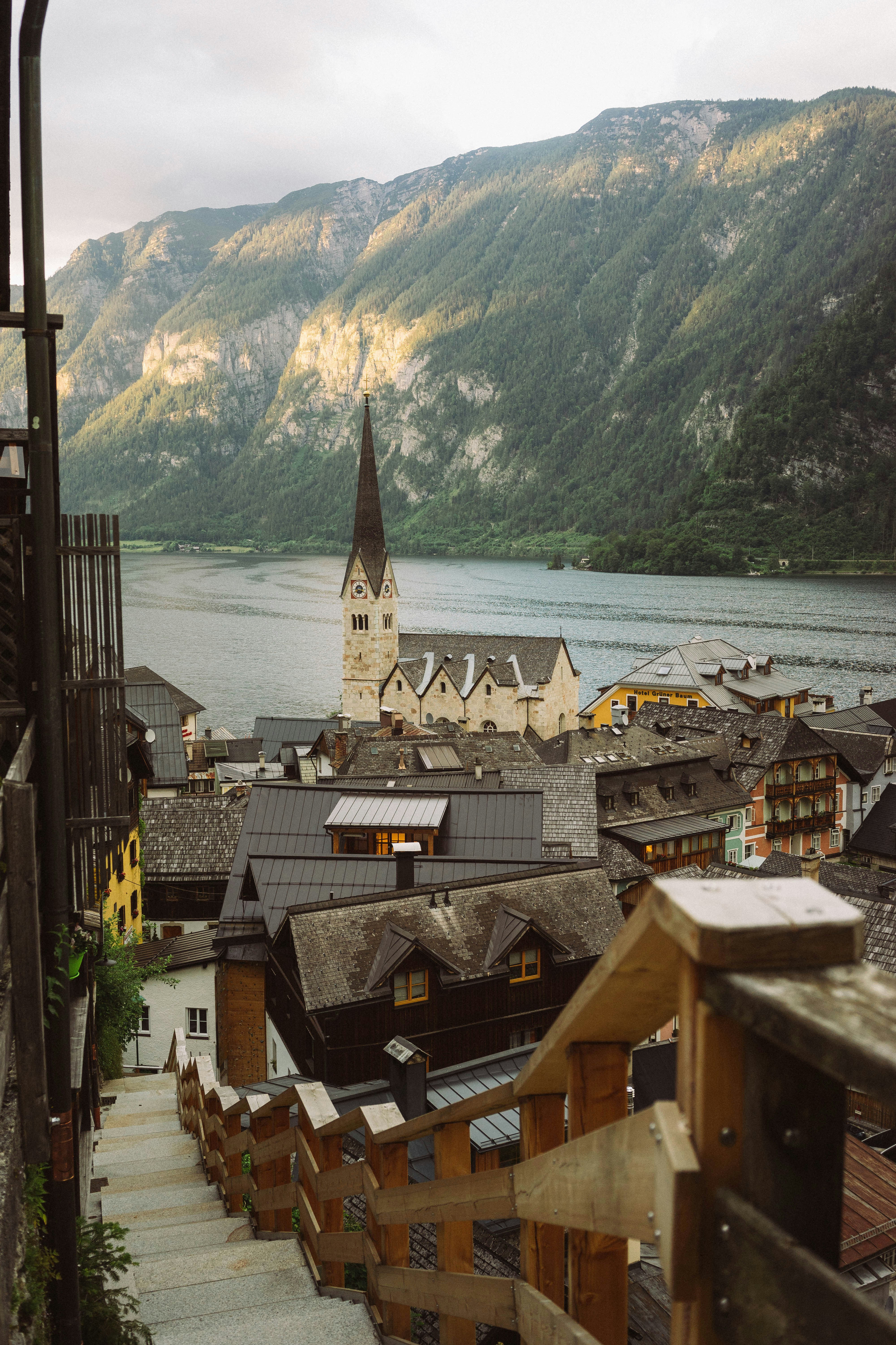 Staircase to the Spire: An Alpine Village Framed by a Serene Lake and Mountain Backdrop