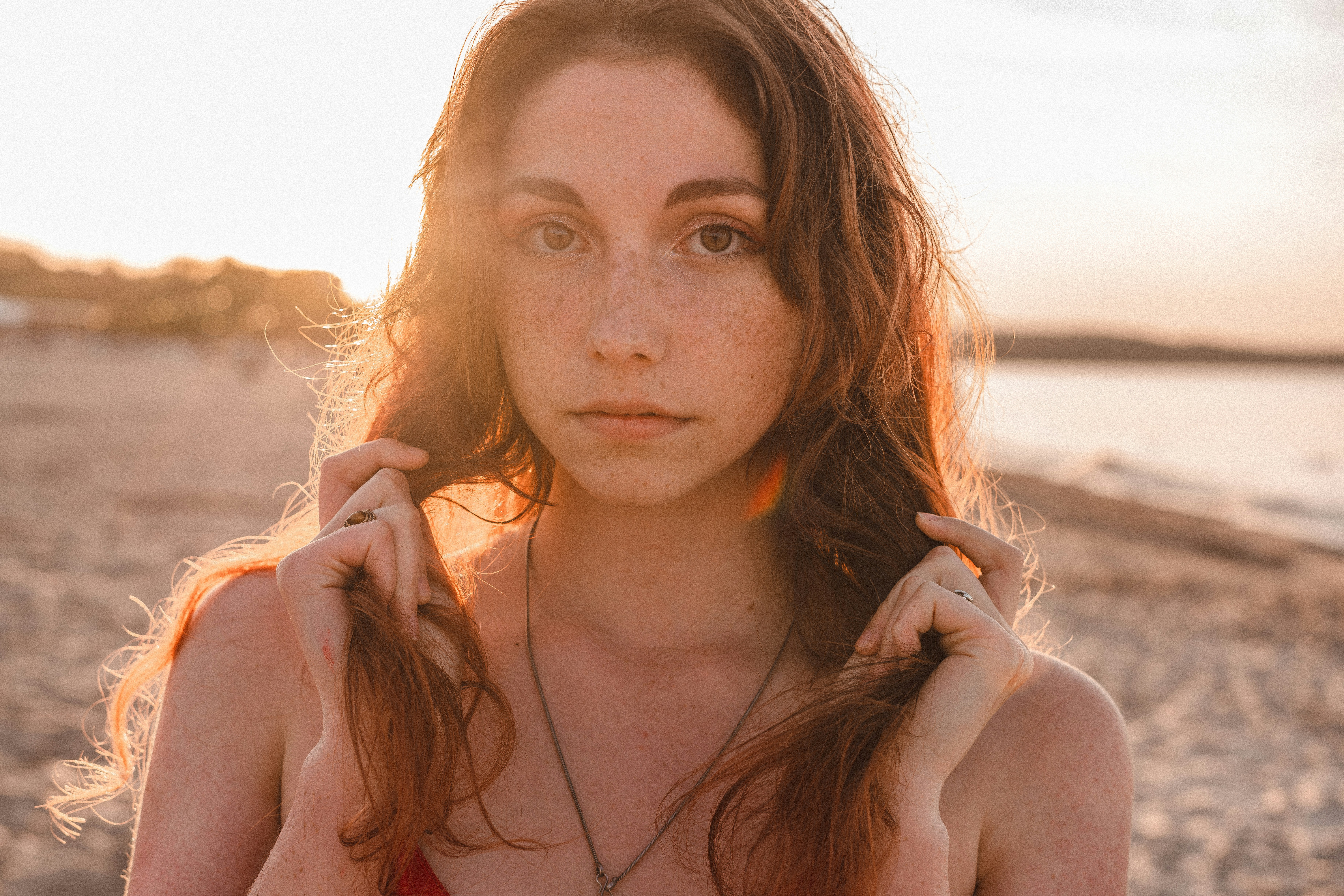 Una mujer con cabello pecoso parada en una playa foto – Imagen de ...