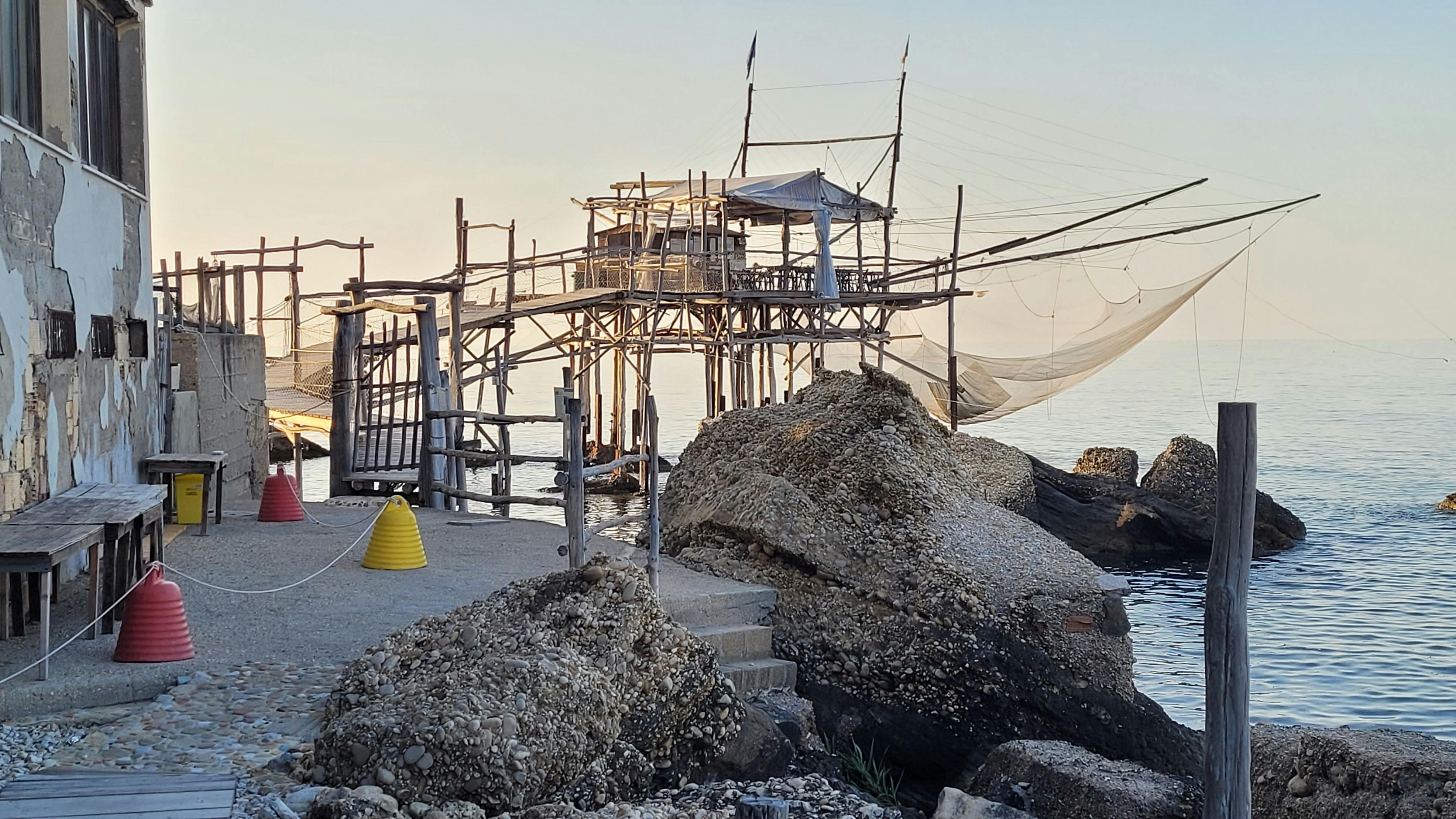Fishing nets and wooden pier cast in the calm harbor glow