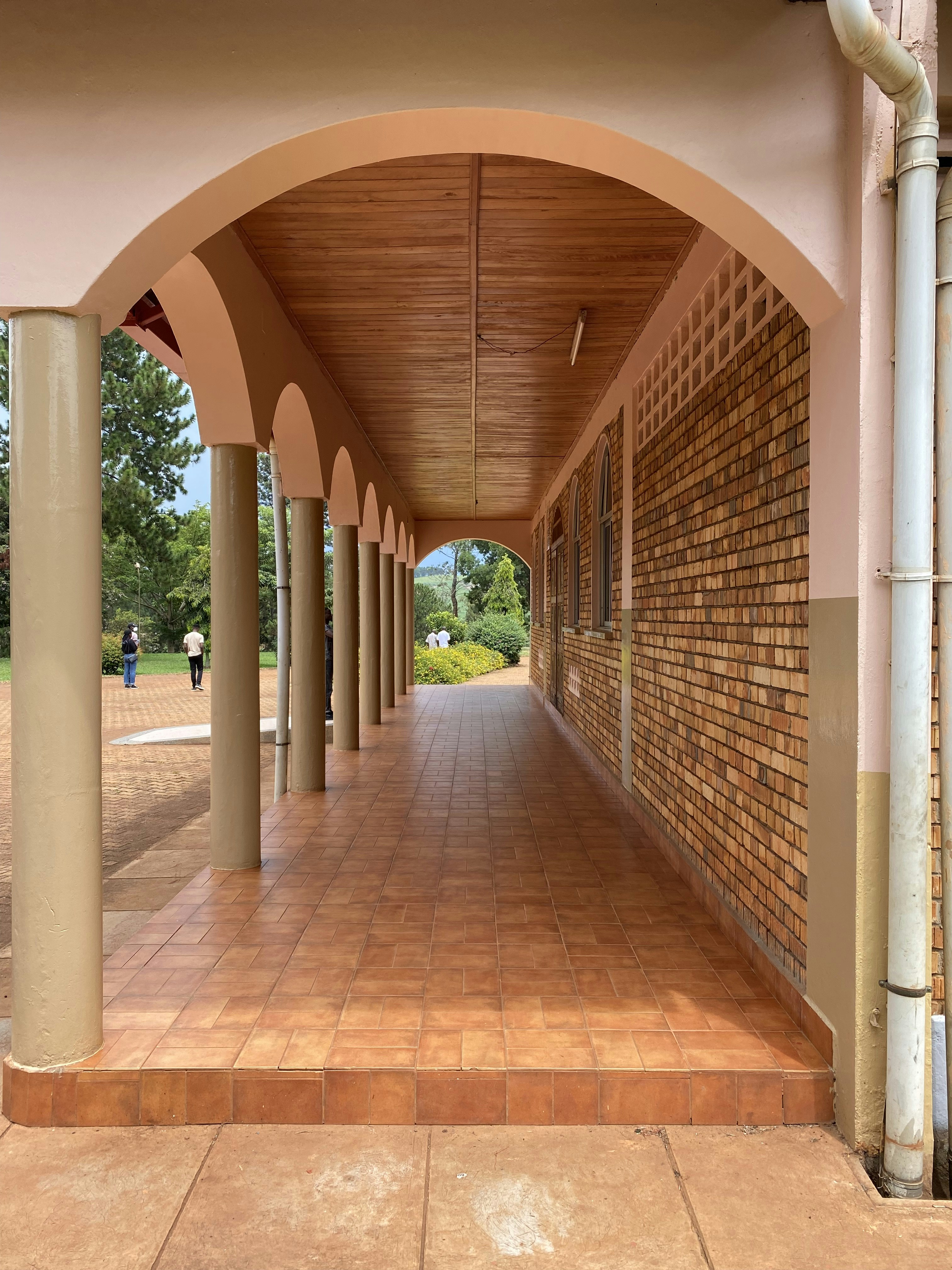 Sunlit Colonnade: Brick Arches Leading to a Distant Arch