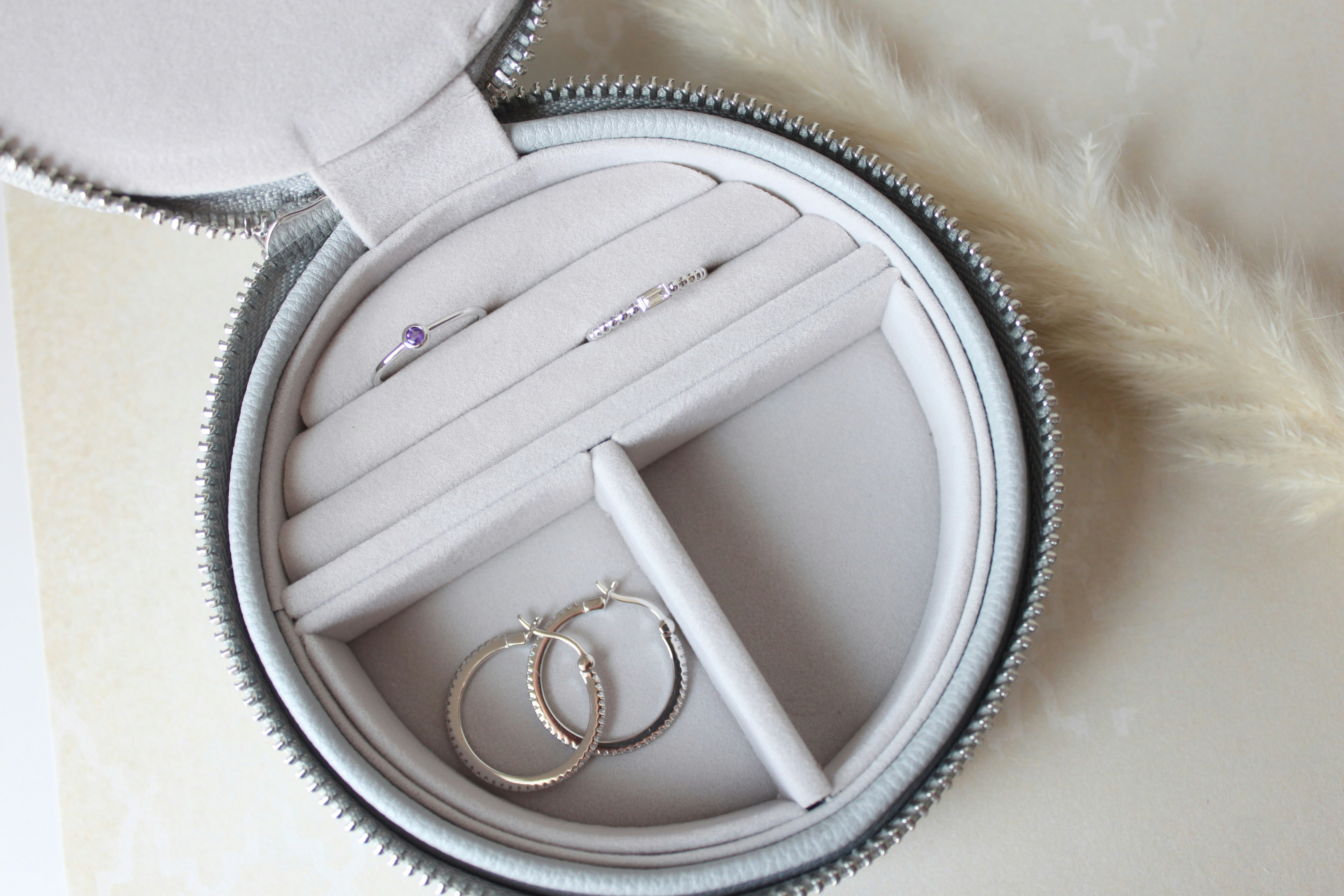 Jewelry case featuring neatly arranged rings and earrings on soft compartments, showcasing an organized display. 