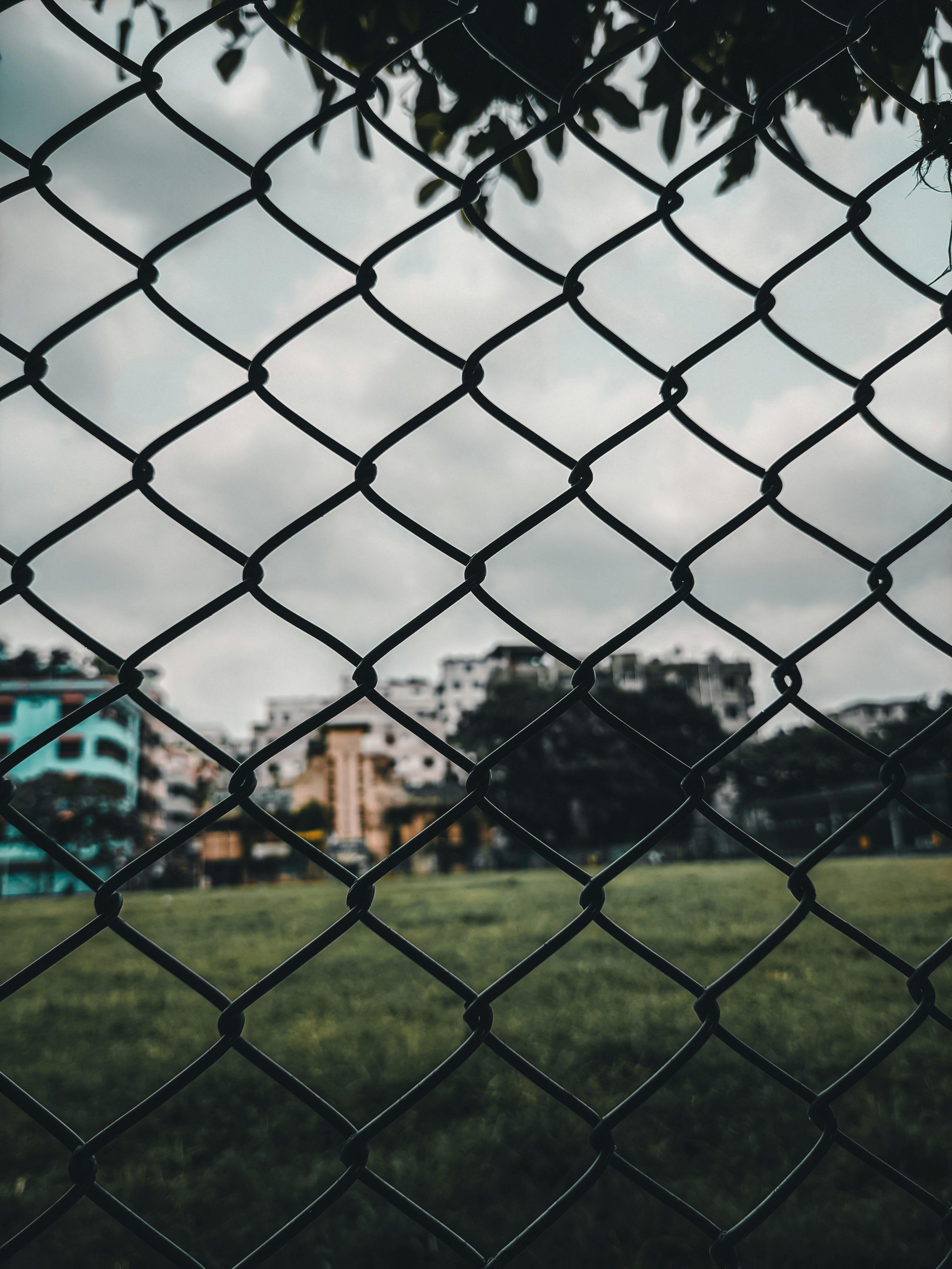 A grassy field behind a chain link fence photo – Free Grey Image on ...