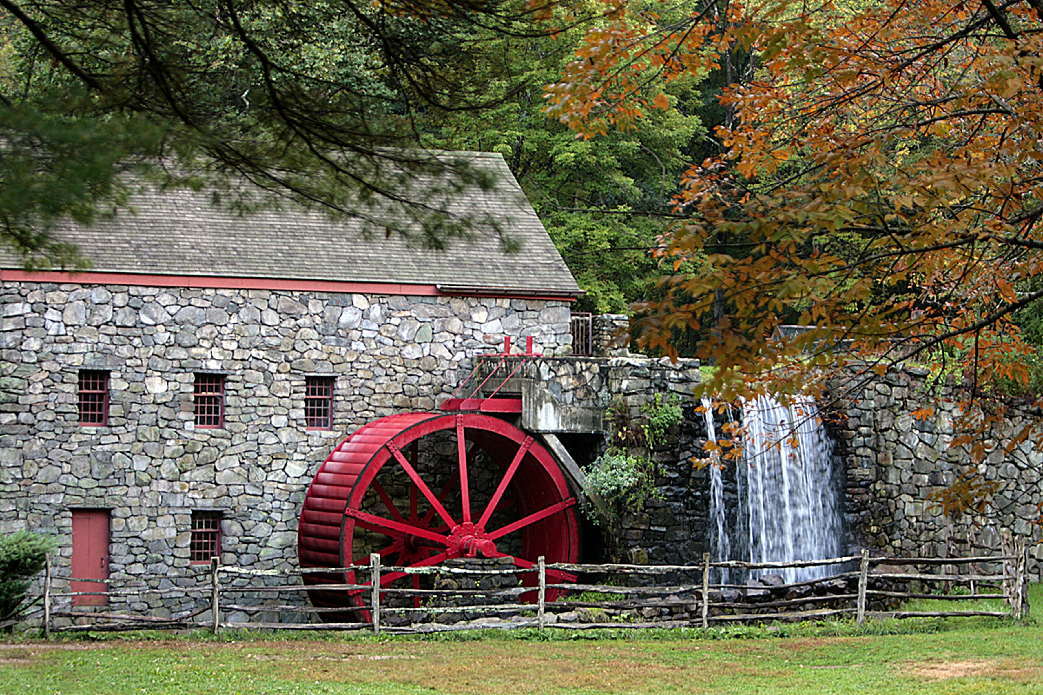 A red water wheel in front of a stone building photo – Free Sudbury ...